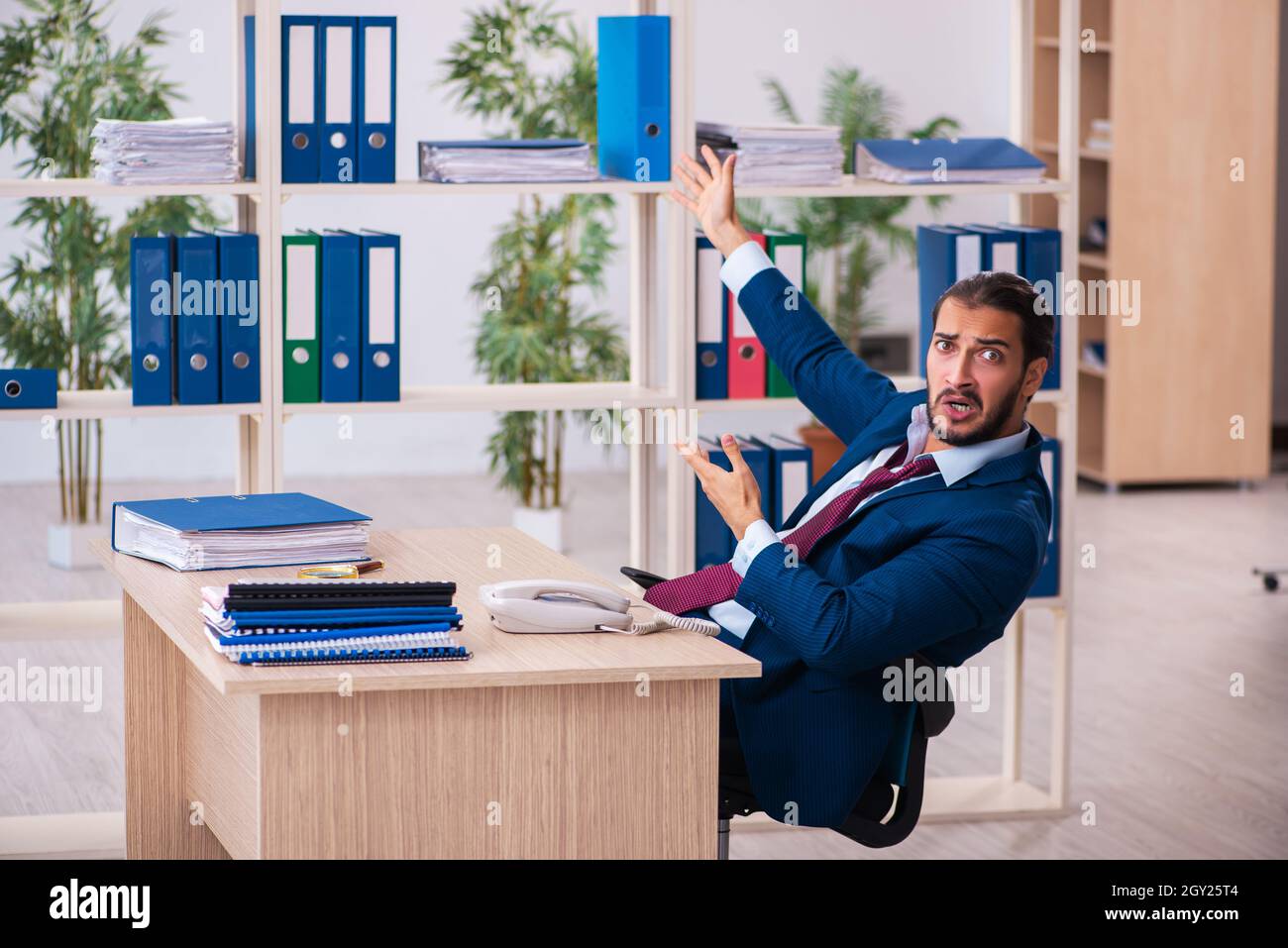 Young employee and too many work in the office Stock Photo - Alamy