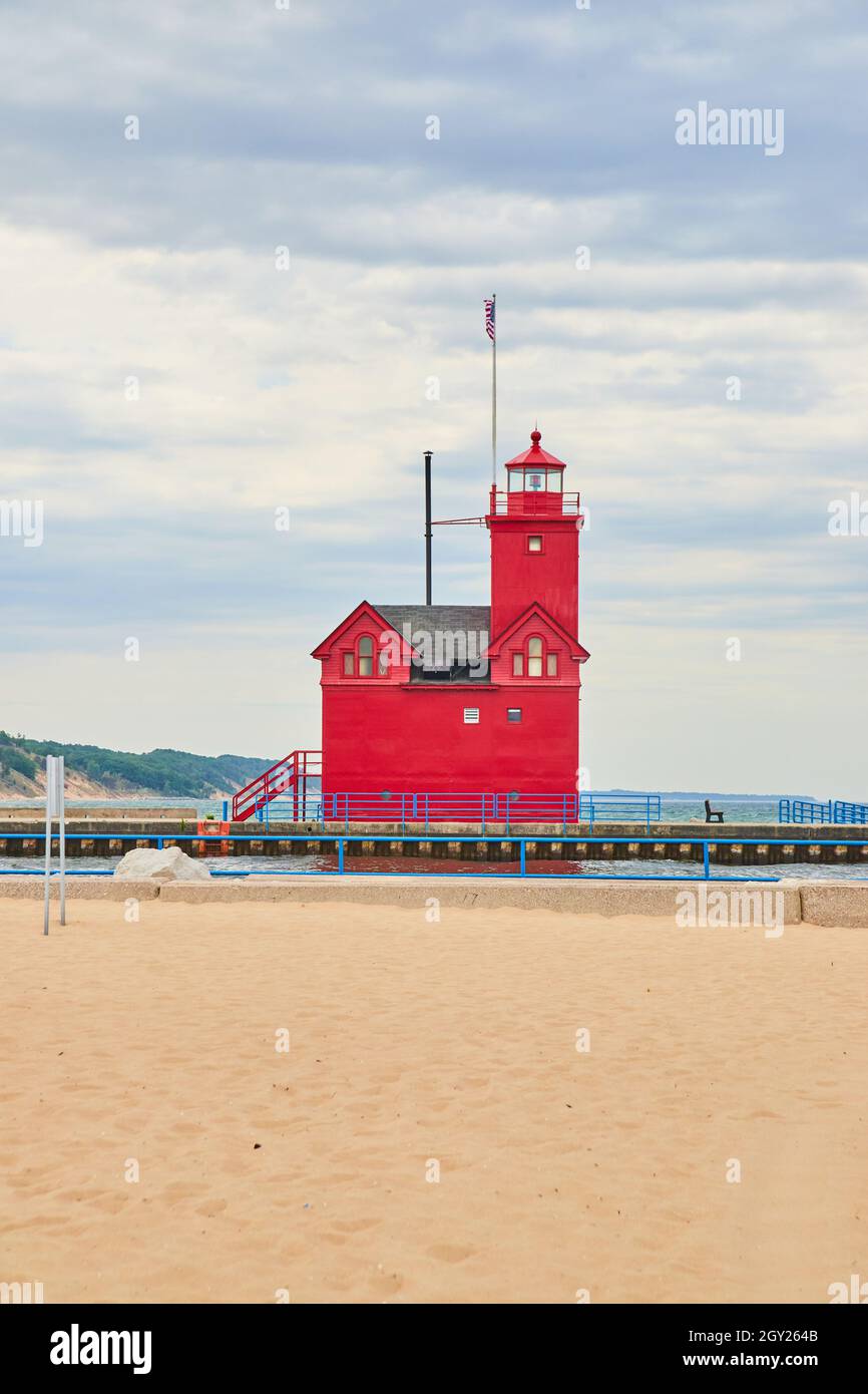 View of red lighthouse in Michigan with sandy beaches and blue railing ...