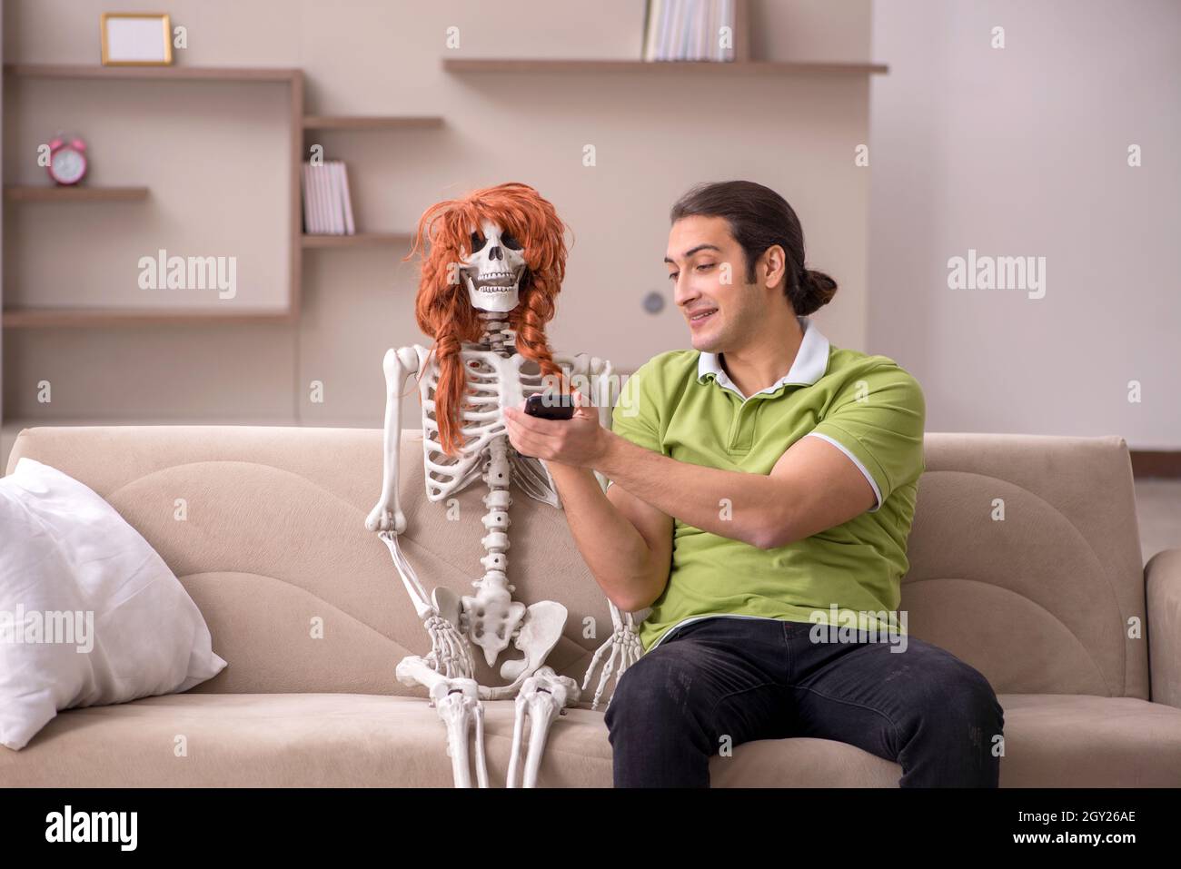 Man sitting on the sofa with female skeleton Stock Photo - Alamy