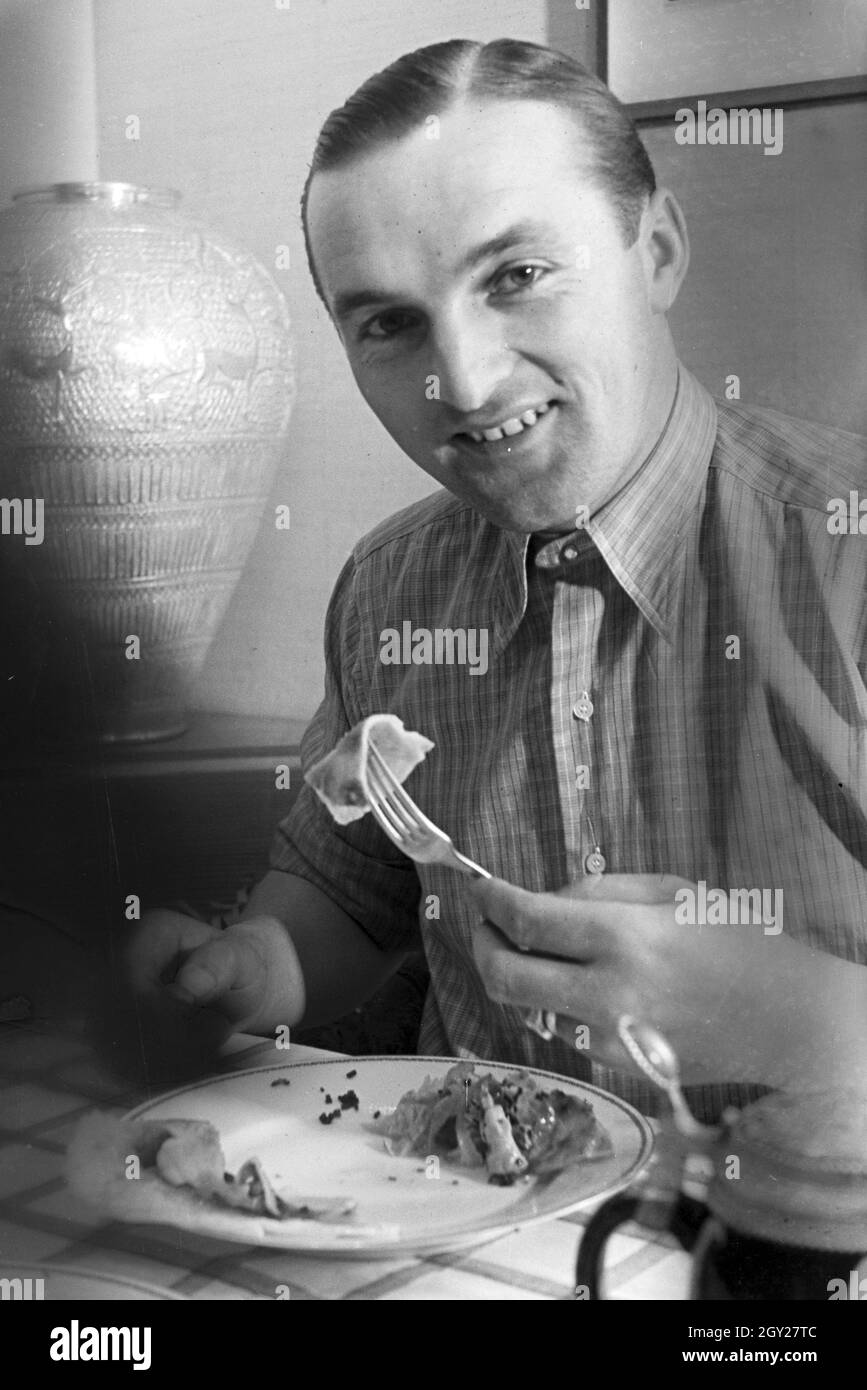 Der Autorennfahrer Hermann Lang beim Essen mit seiner Familie ...