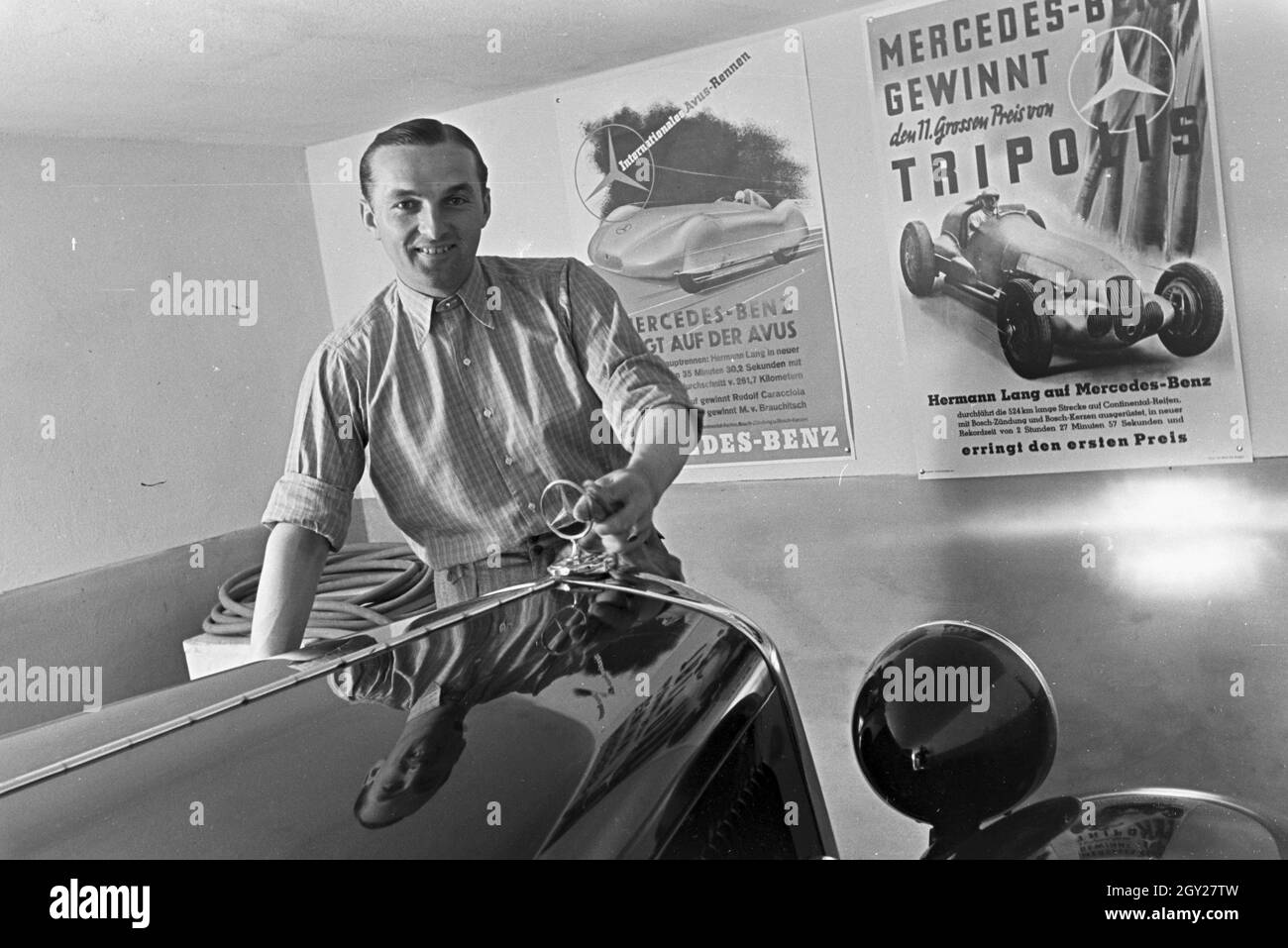 Der autorennfahrer hermann lang poliert den mercedes stern seines autos ...