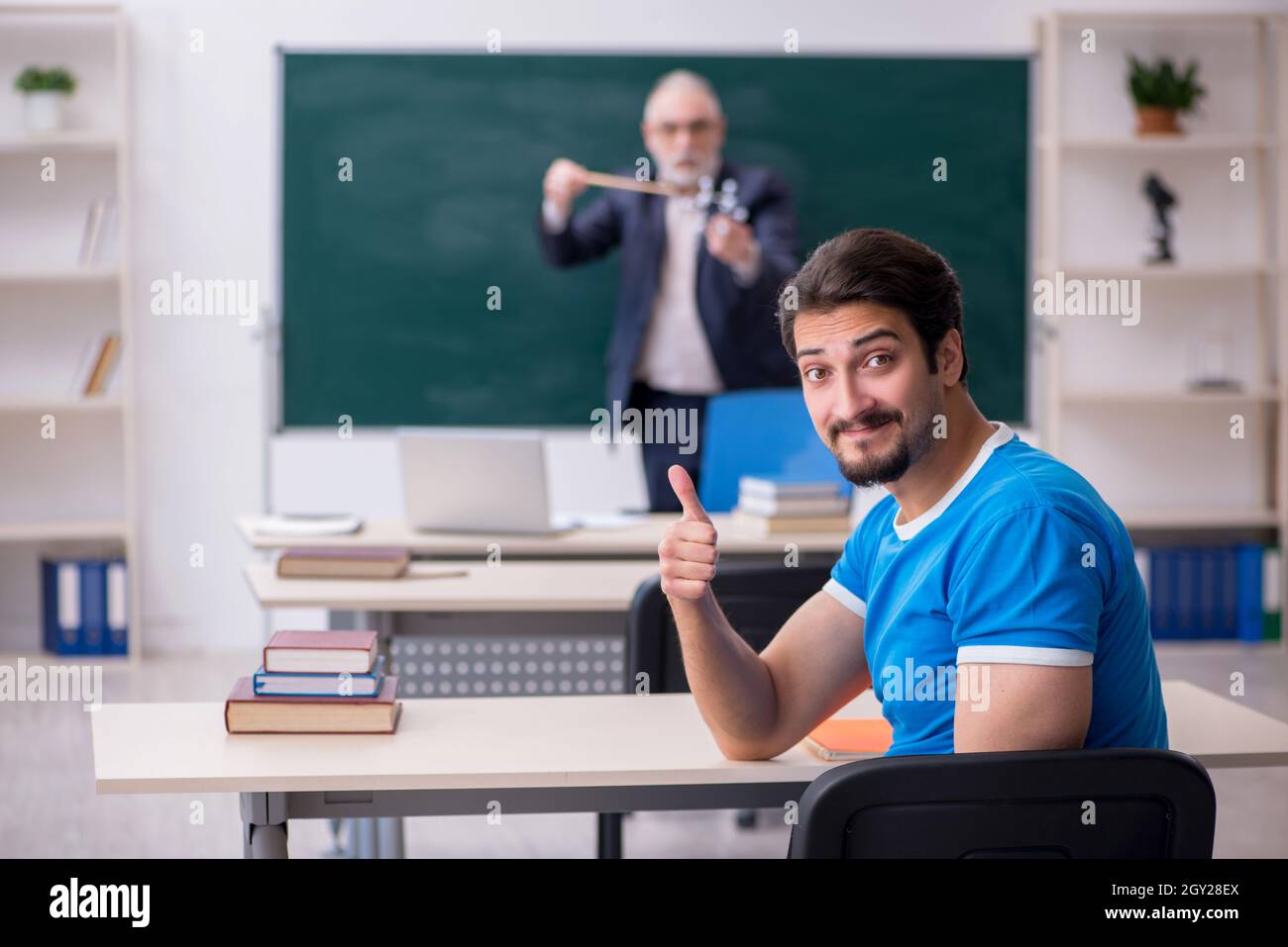 Old physics teacher and young male student in front of blackboard Stock ...