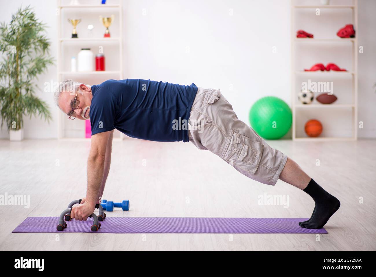 Old man doing sport exercises at home Stock Photo - Alamy