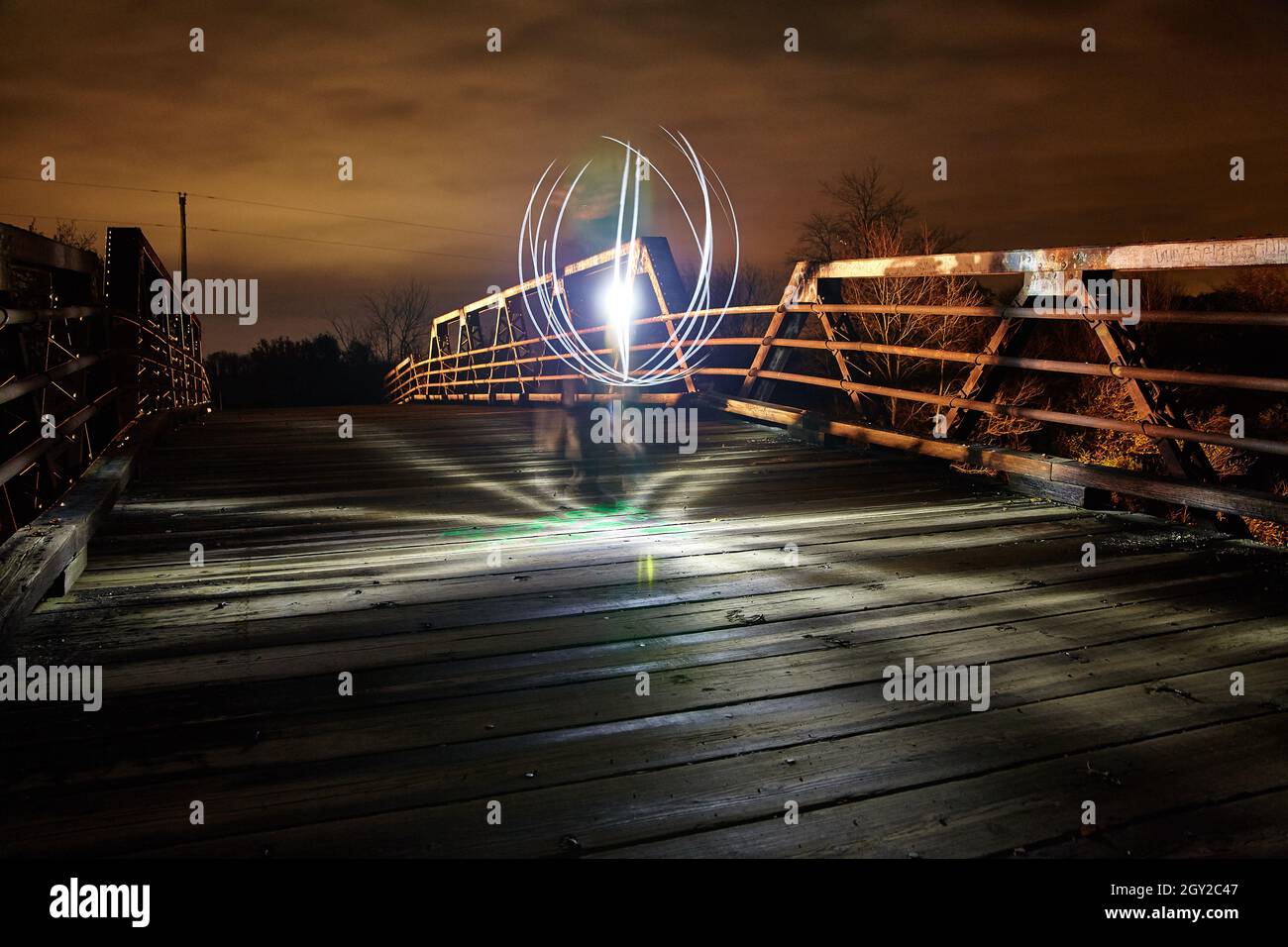 Crisp glowing white light floats on a metal bridge at dusk Stock Photo ...