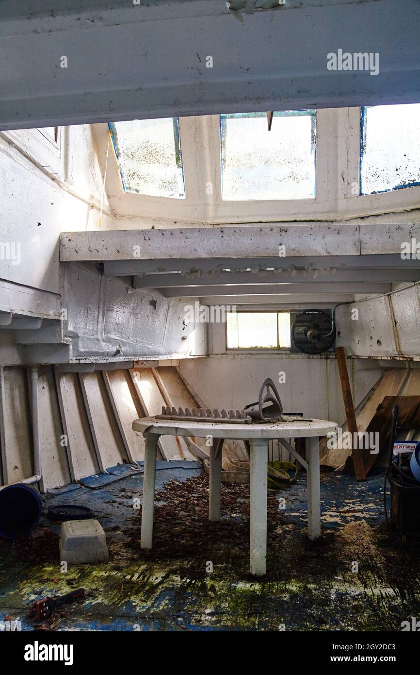 Abandoned room with white walls and windows and a white table with a ...