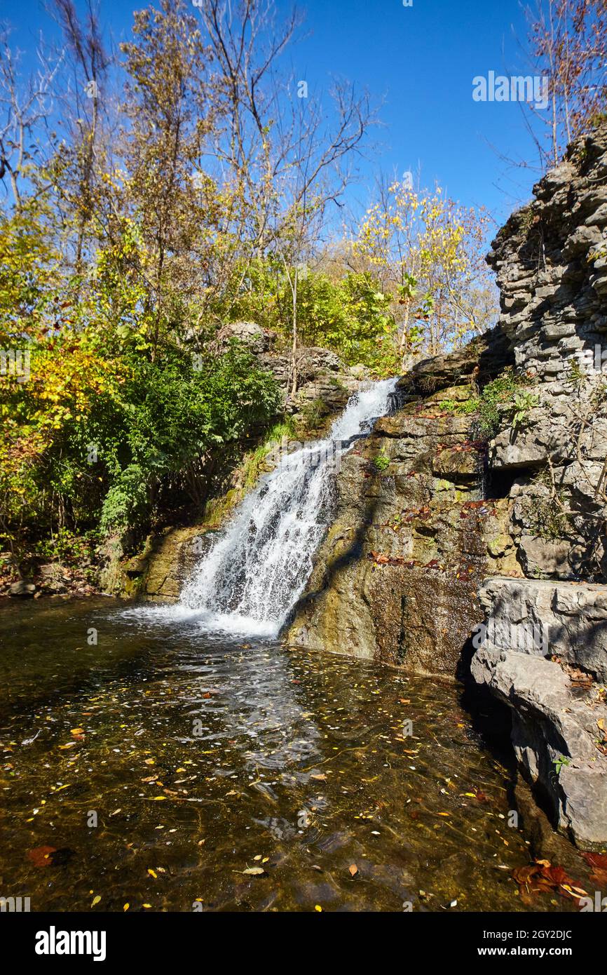 Small waterfall over rocks into pond fall Stock Photo - Alamy