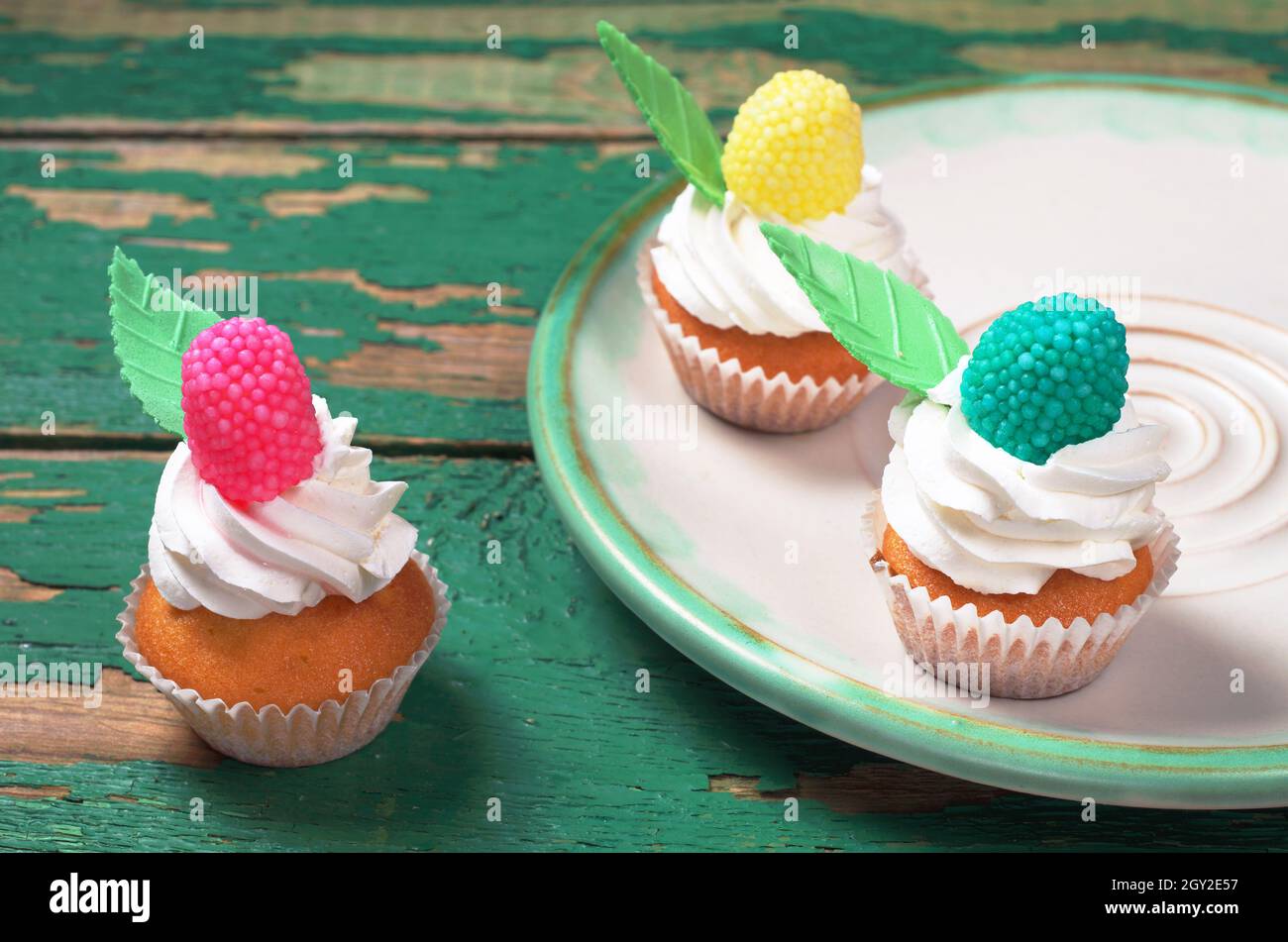 Colorful small cakes on old green background Stock Photo - Alamy