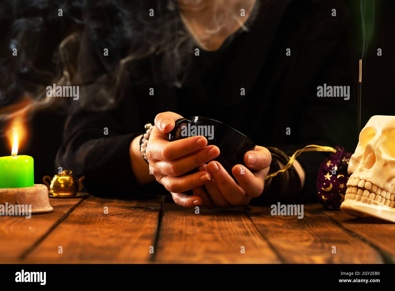 Fortune teller or oracle with a black cup in hand for fortune telling ...