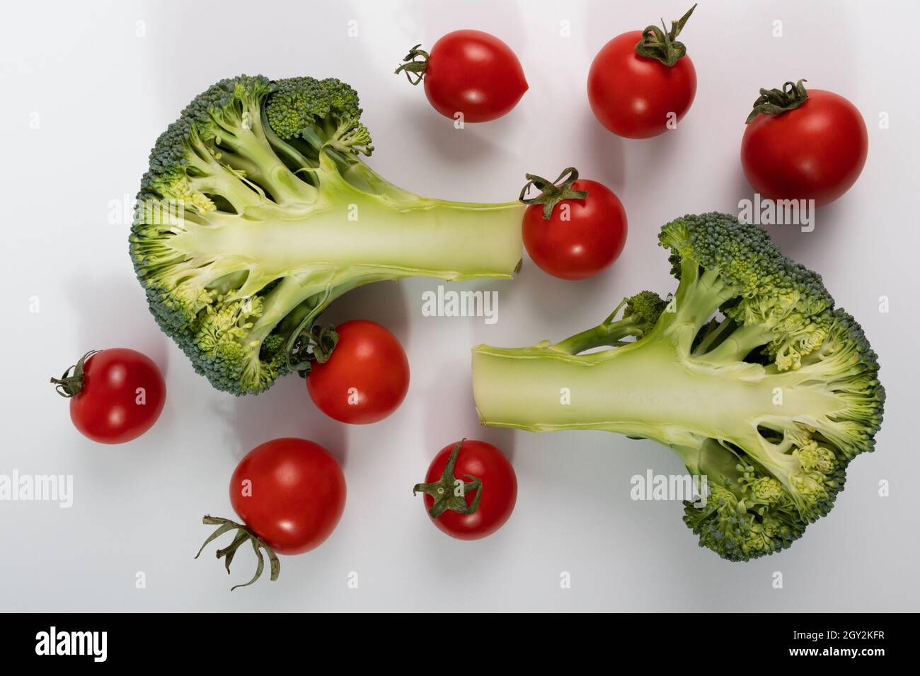 Broccoli with cherry tomatoes on a white, closeup. Healthy vegetables ...