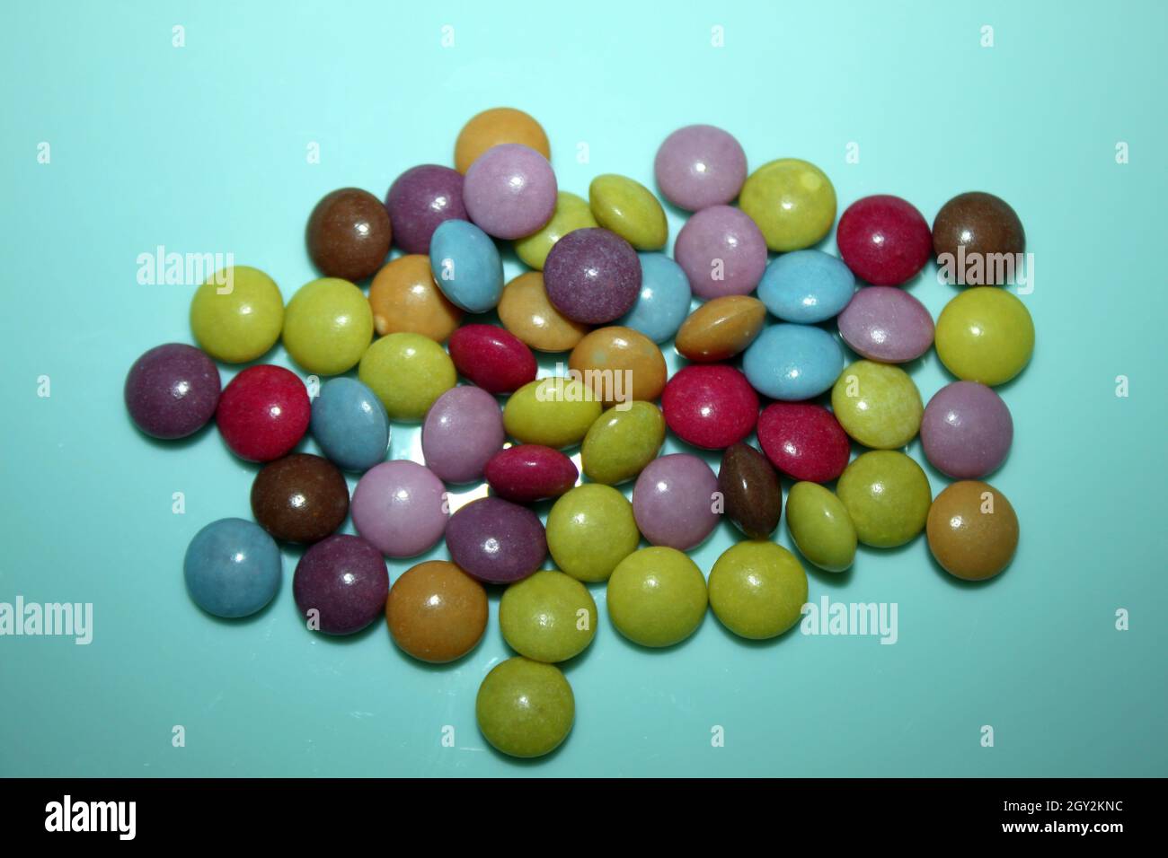Multicolor chocolate candies on turquoise plate Stock Photo - Alamy