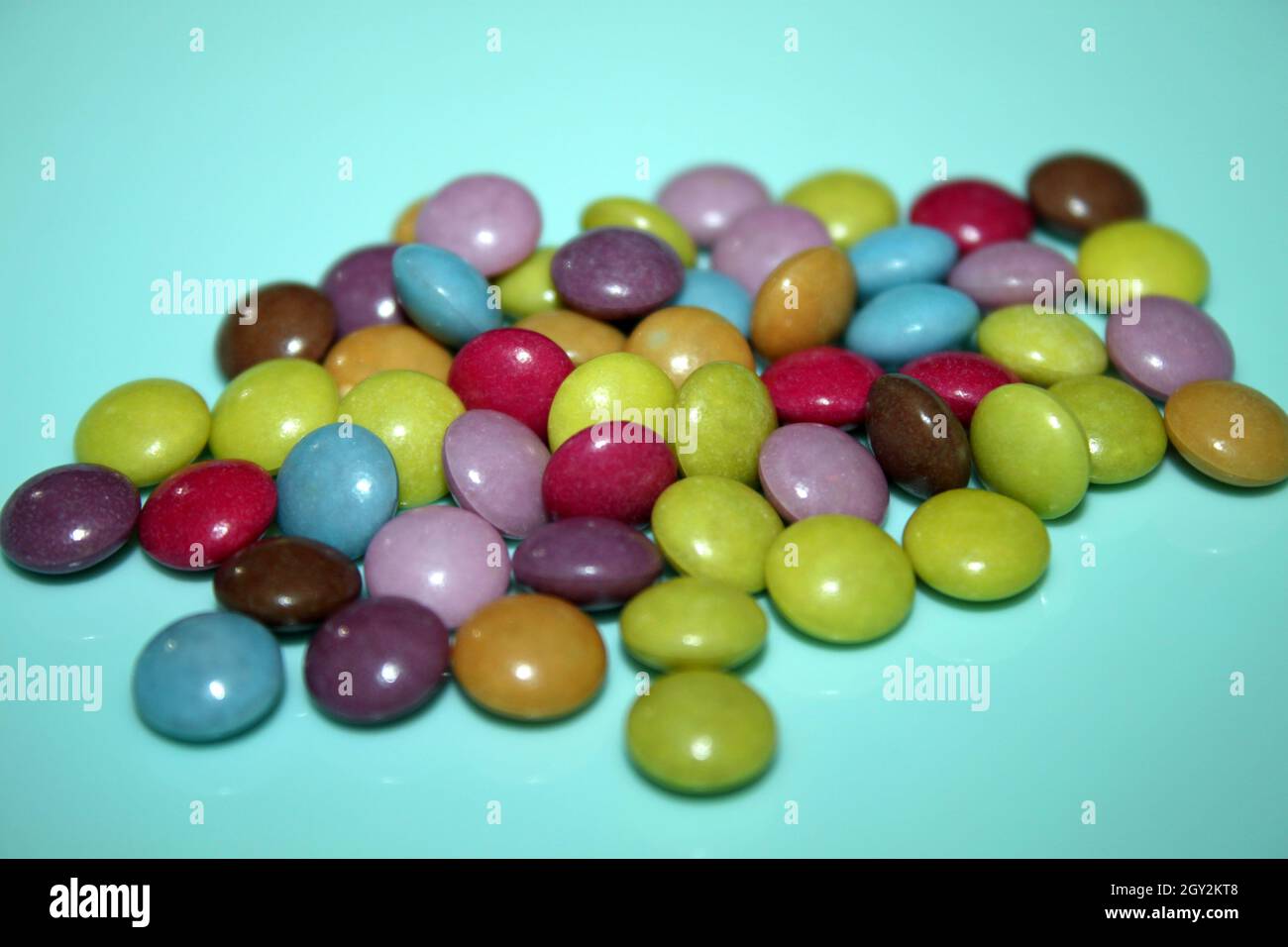 Multicolor chocolate candies on turquoise plate Stock Photo - Alamy