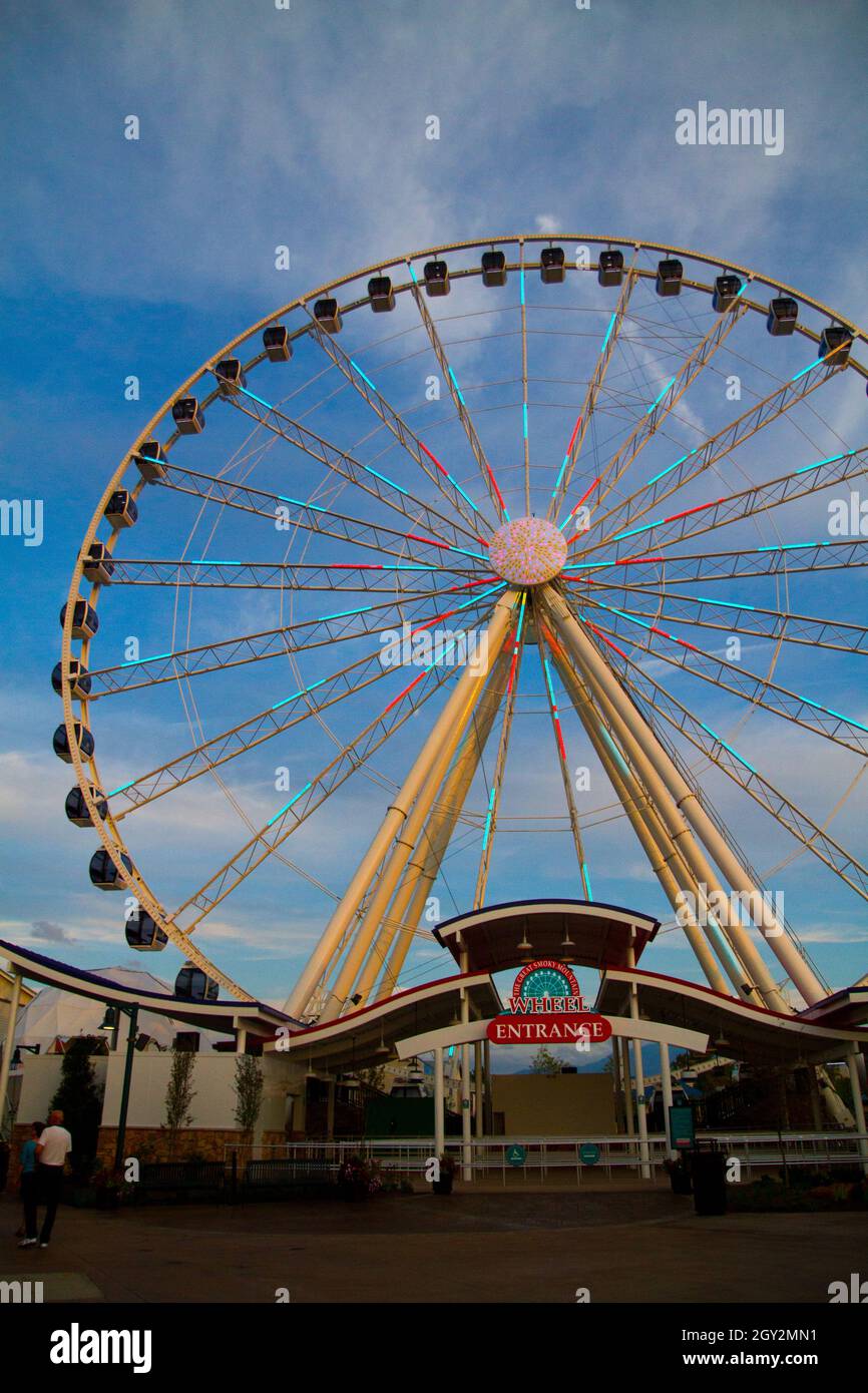 A ferris wheel begins to light up at twilight with no one in line to ...