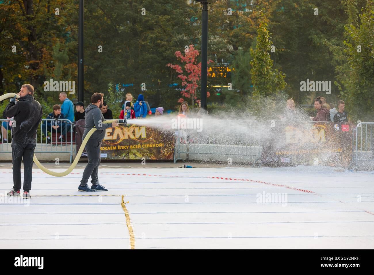 A man covers a section of a pipe with artificial snow. Shooting a film ...