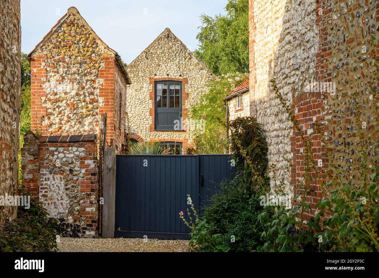 Drive and gated yard to old brick and flint stone houses, now private ...