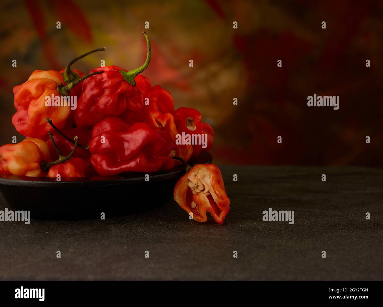 Moody low key food still life of Scotch bonnet peppers Stock Photo - Alamy