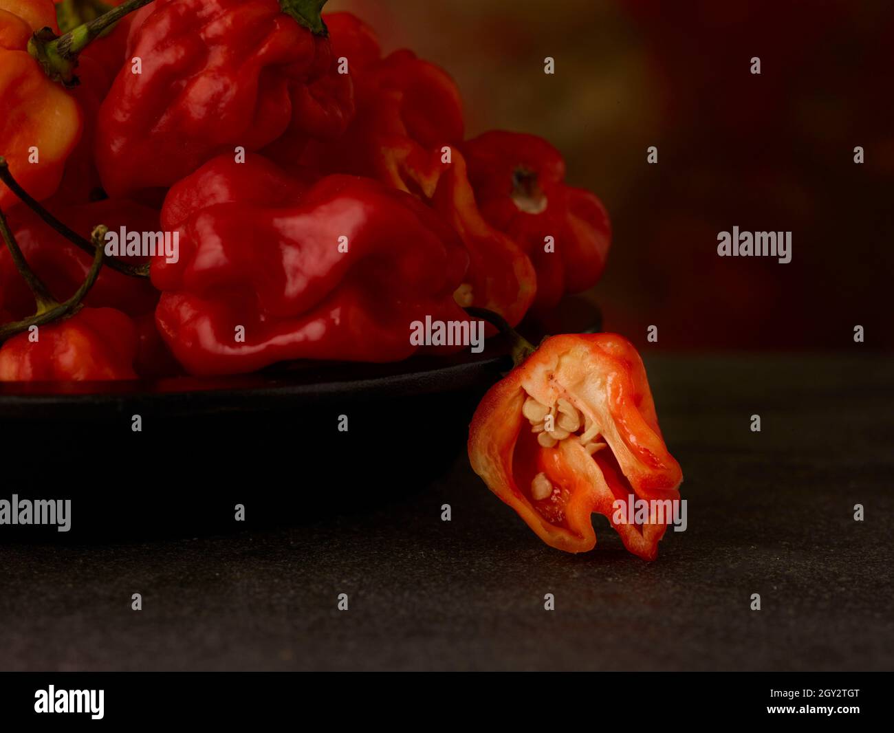 Moody low key food still life of Scotch bonnet peppers Stock Photo - Alamy