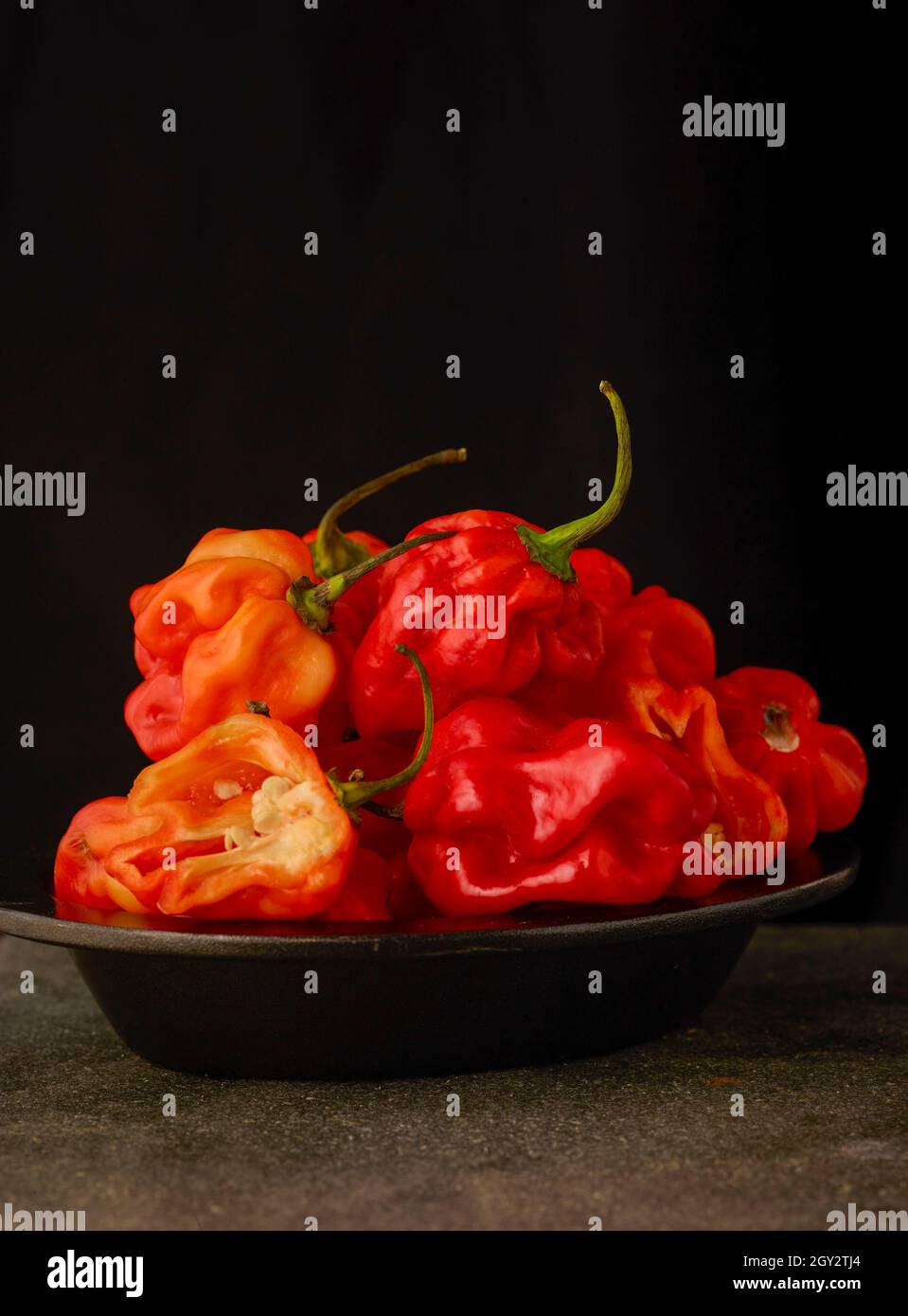 Moody low key food still life of Scotch bonnet peppers Stock Photo - Alamy