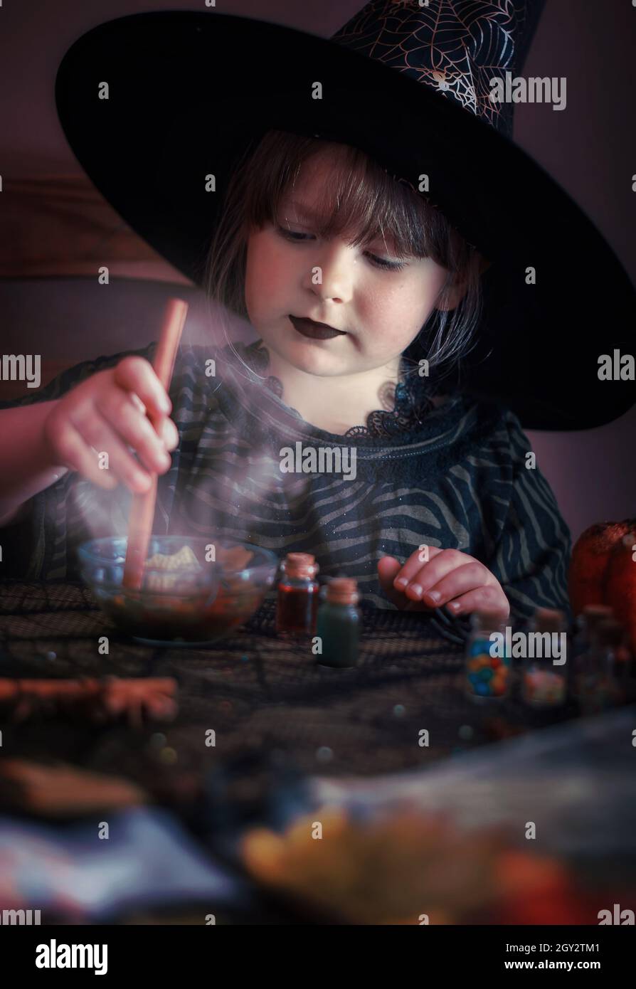 Cute little girl dressed up as a witch, brewing up a potion Stock Photo ...