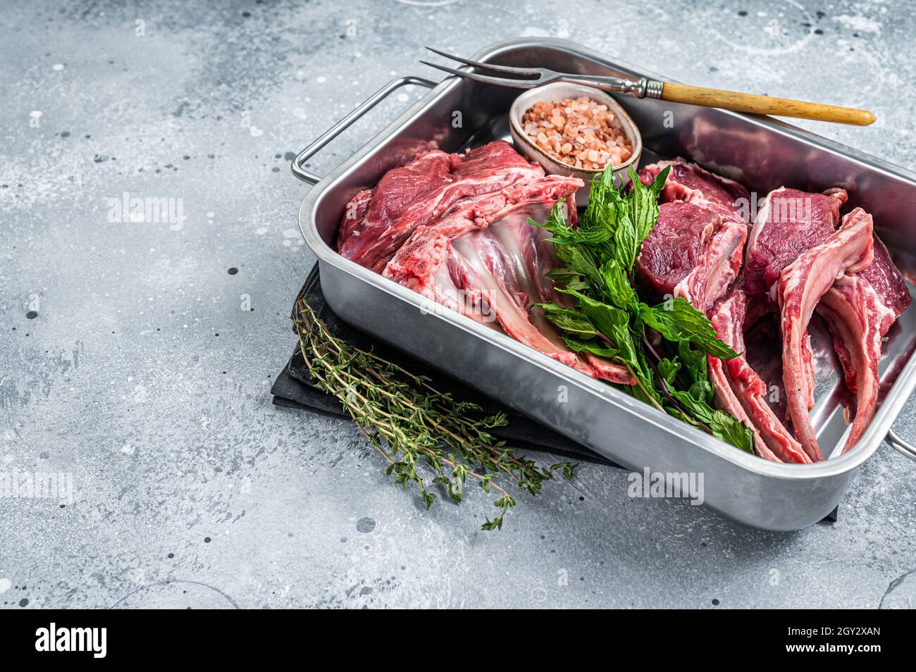 Uncooked Raw lamb, mutton chops in a steel kitchen tray. Gray ...