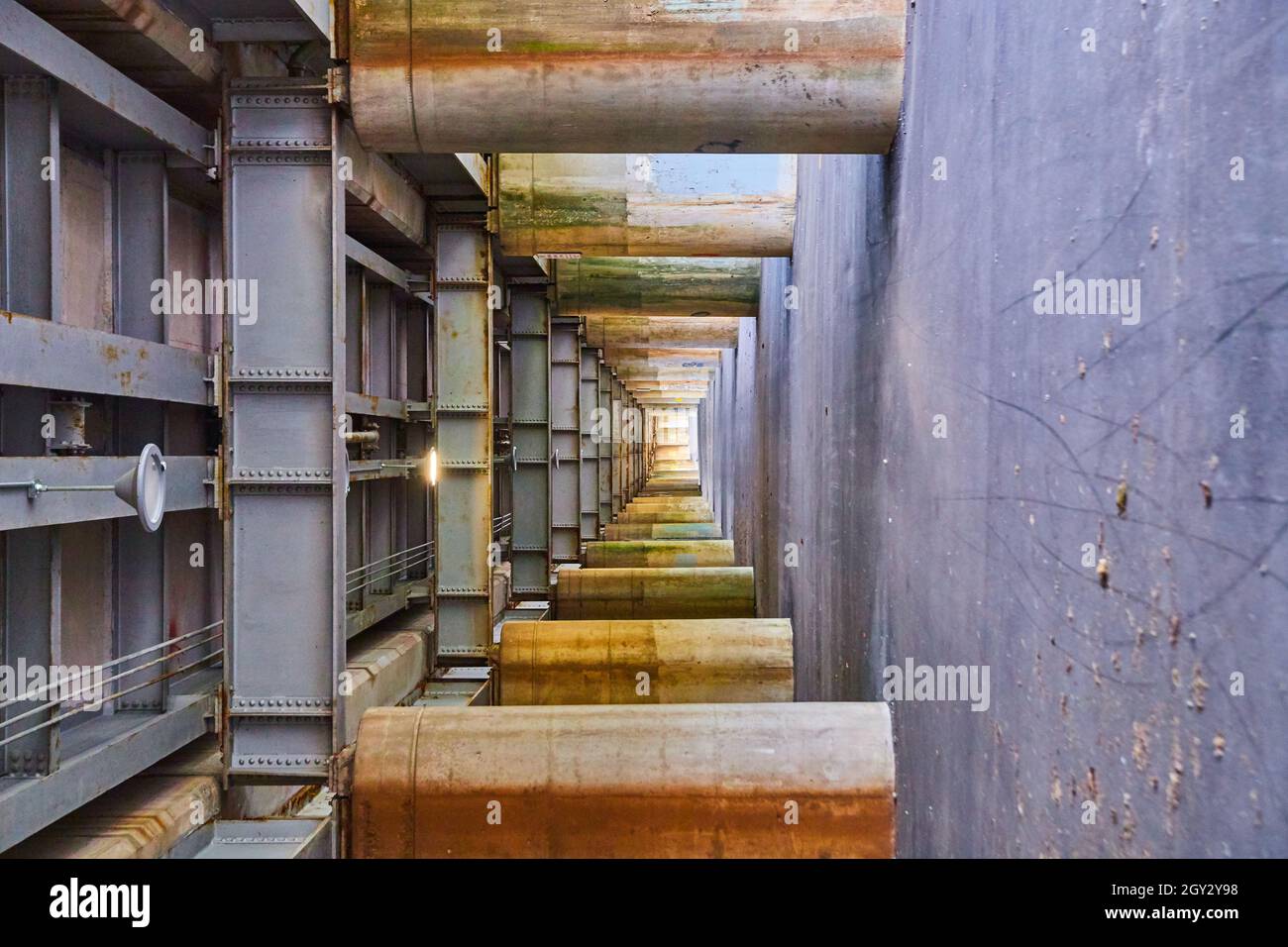 Sideways tunnel of road underneath train tracks with large pillars ...