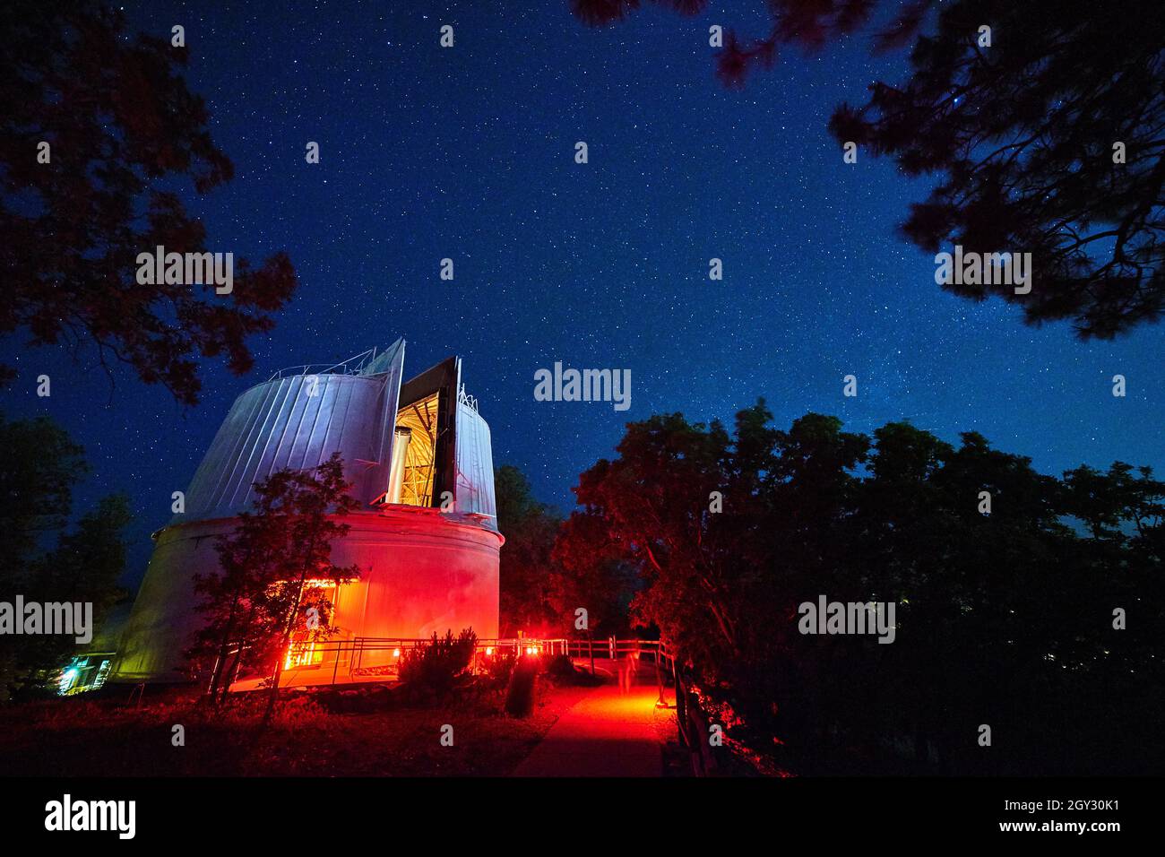 Landscape of an observatory lit up in red and blue lights at night with ...