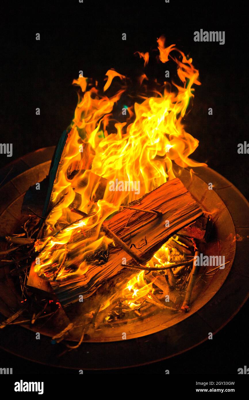 Red and orange fire rages in a metal fire pit Stock Photo - Alamy