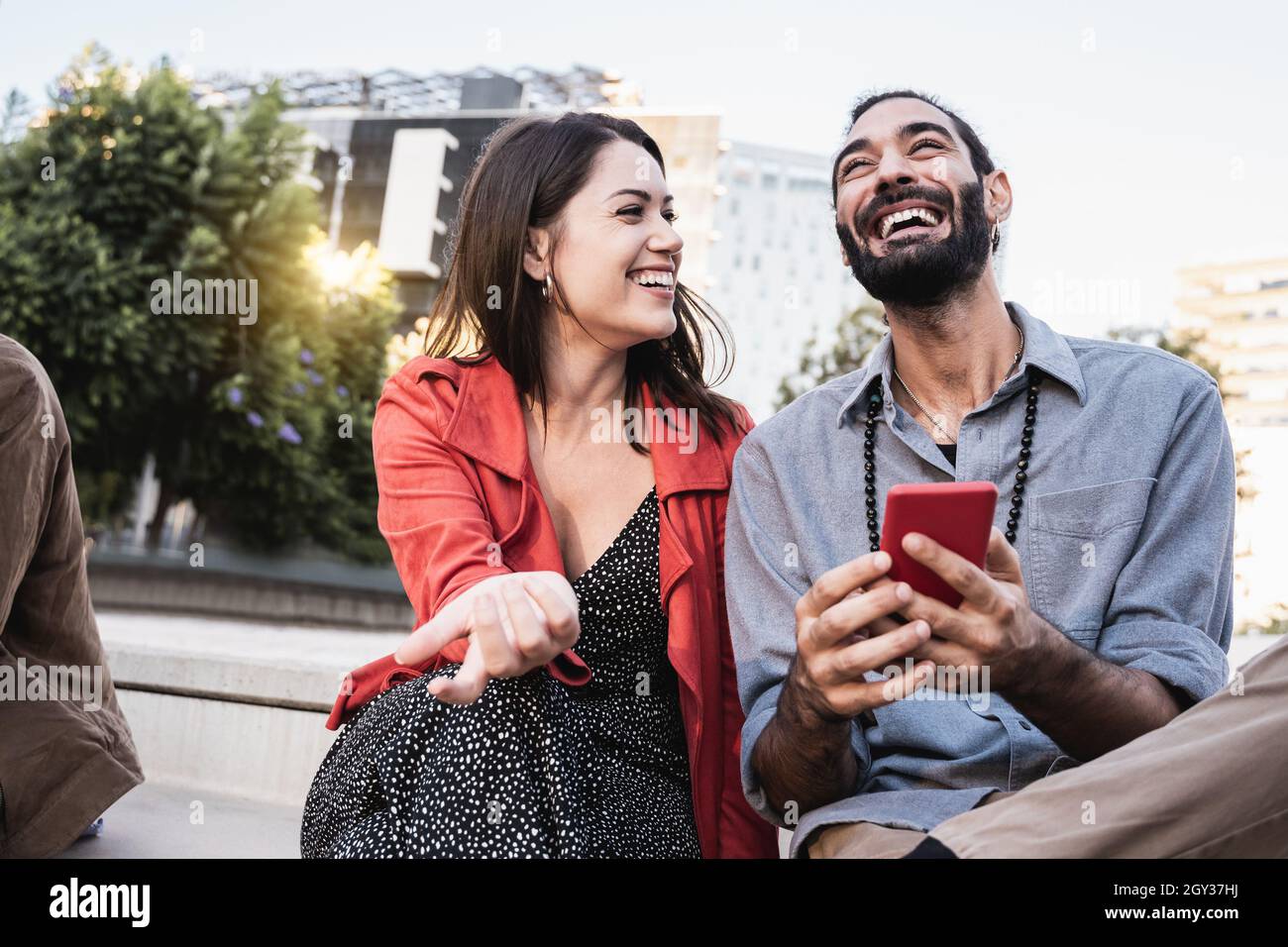 Young happy people using mobile phones outdoor in the city - Focus on ...