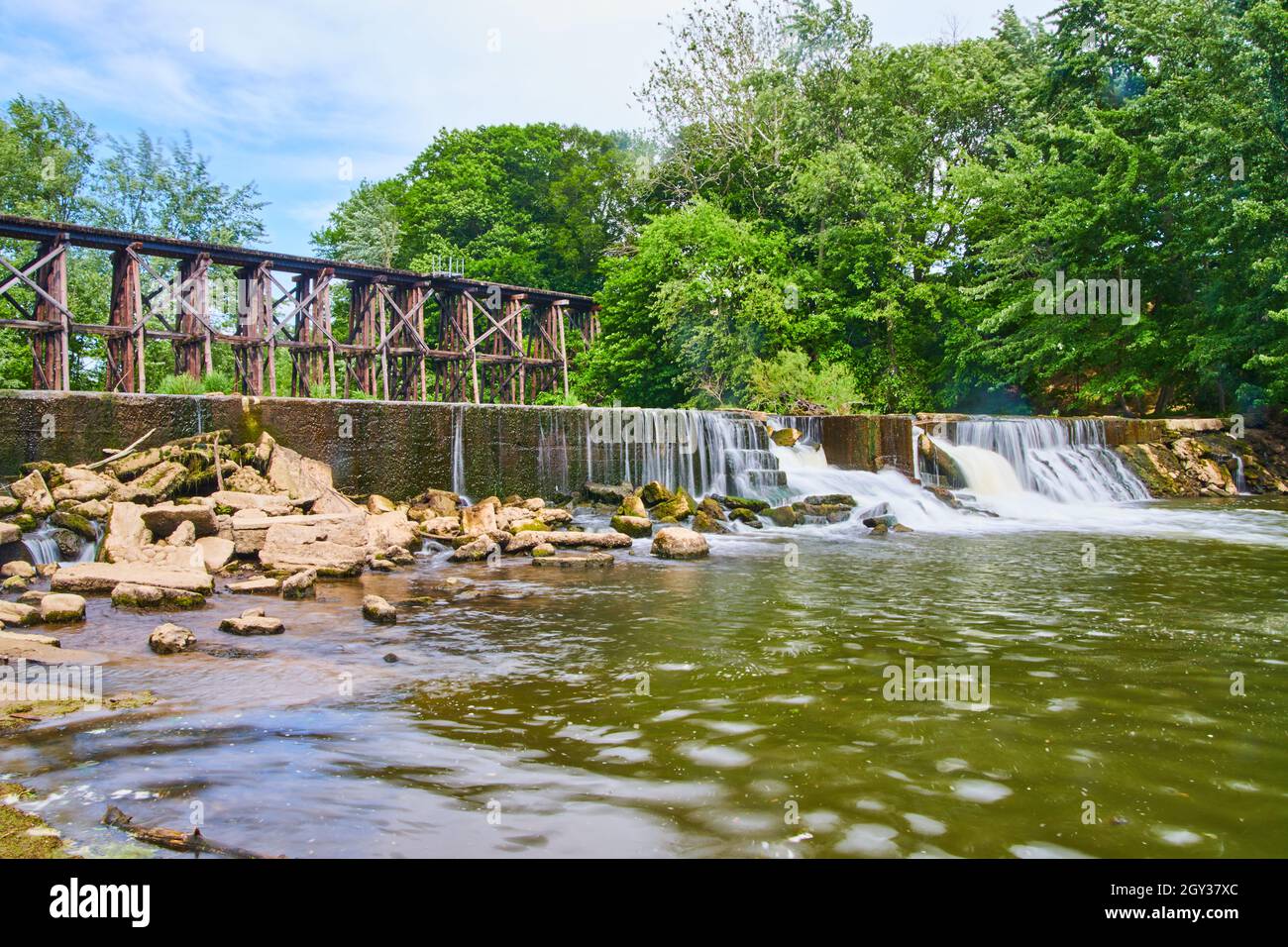 Dam with waterfalls and railroad bridge in background Stock Photo - Alamy
