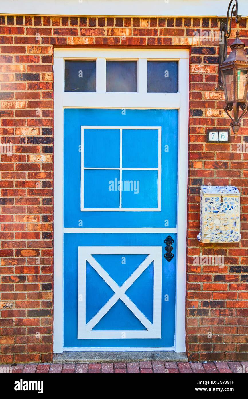 Bright blue and white dutch-style door on red brick Stock Photo - Alamy
