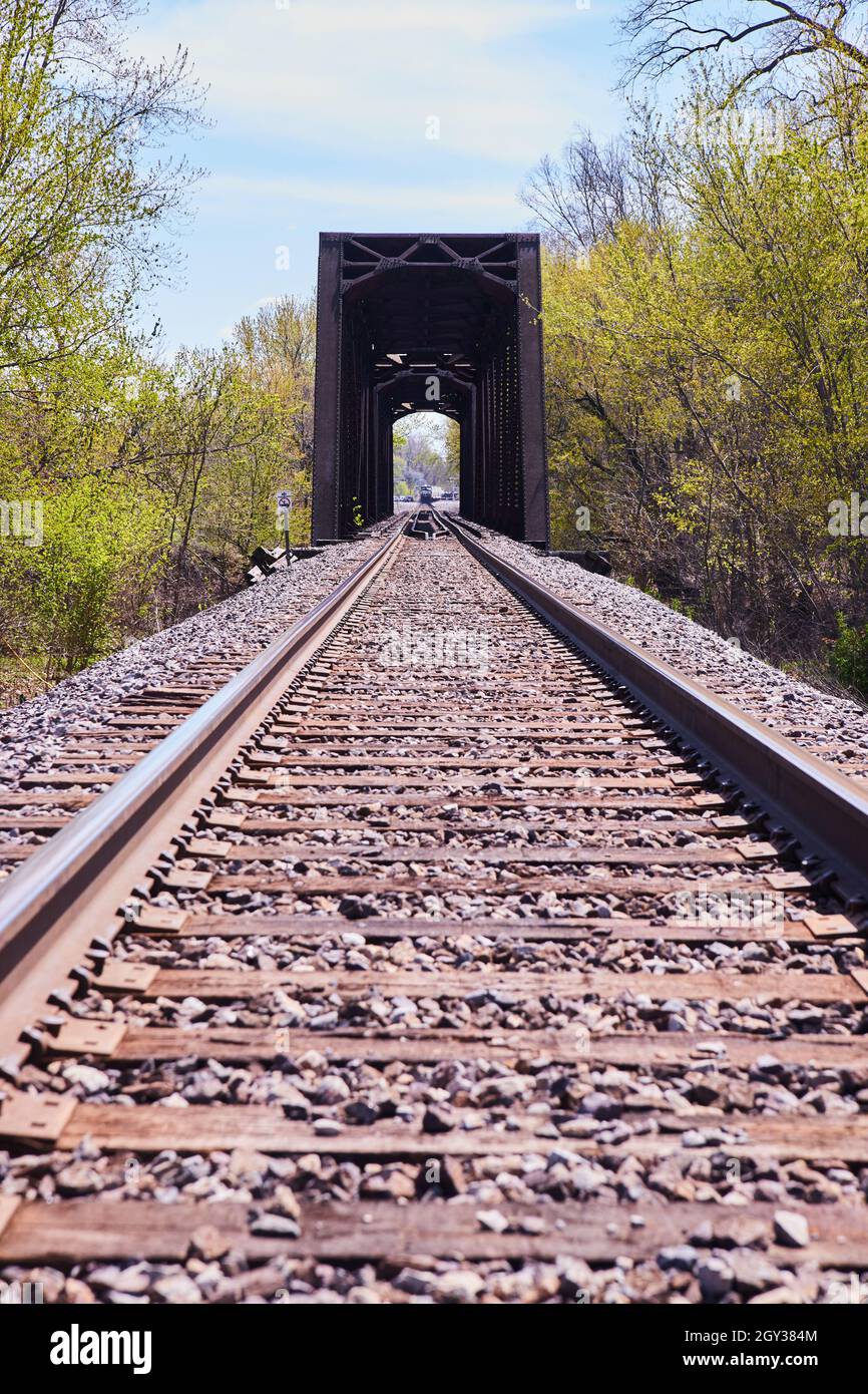 Railroad tracks leading to large metal bridge Stock Photo - Alamy