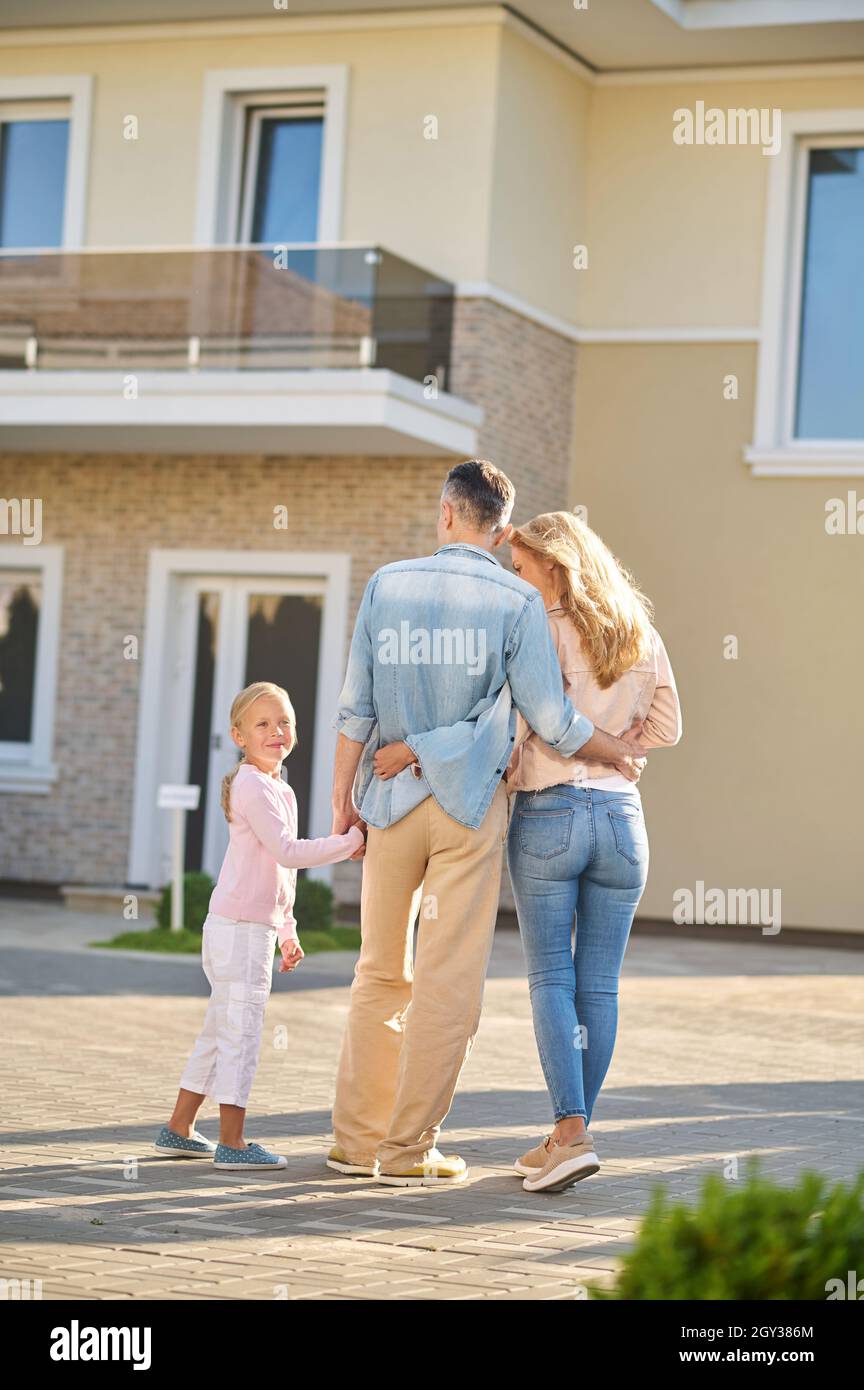 Man with wife and daughter admiring new home Stock Photo - Alamy