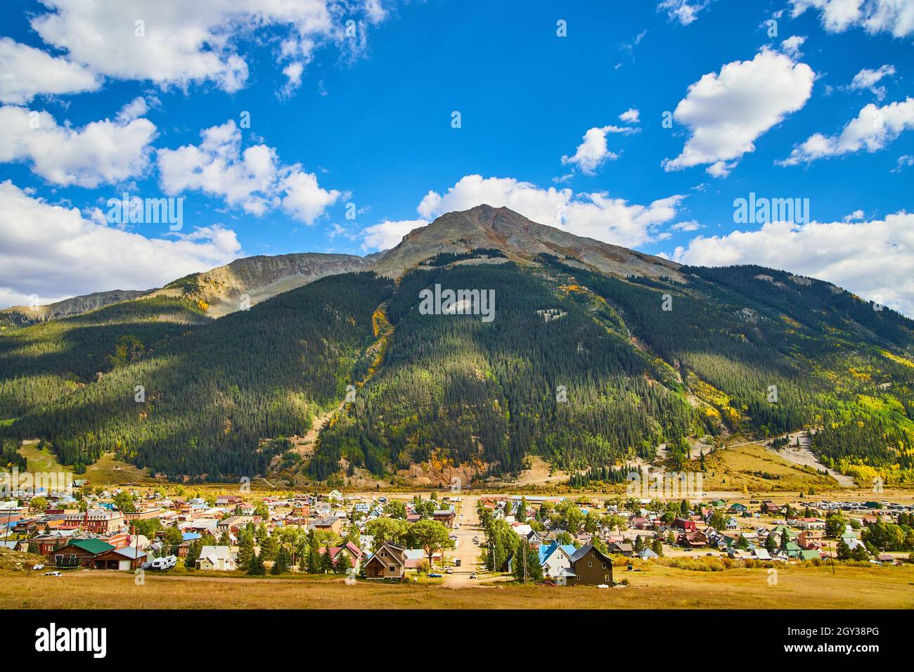 Landscape of mountain range and blue skies behind small mining town ...