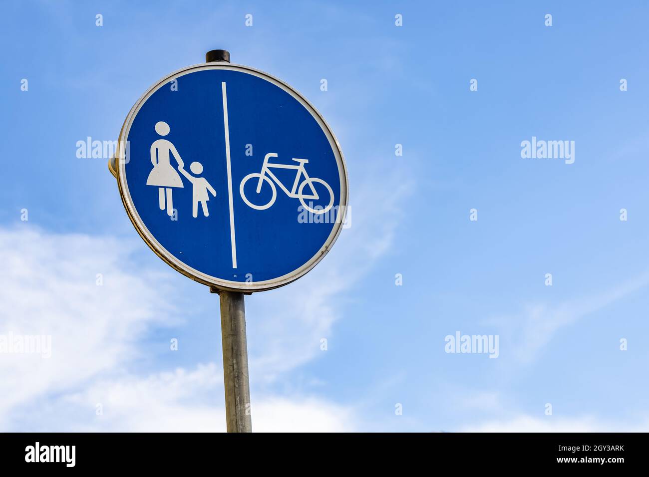 Round, blue sign of a walkway for bicycles and pedestrians Stock Photo ...