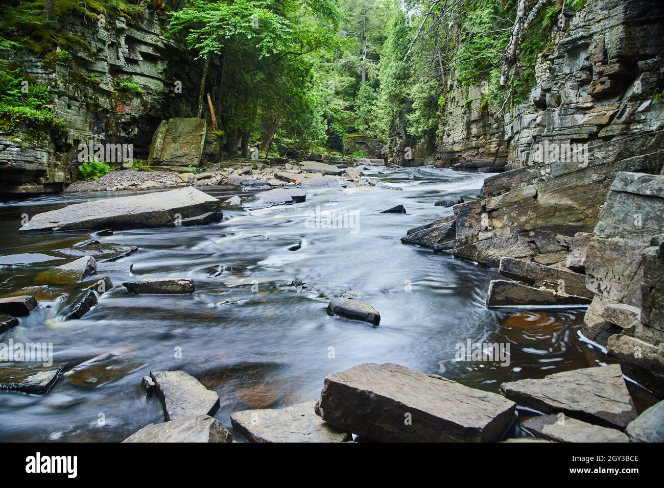 Open river with rocks in gorge surrounded by vertical cliffs Stock ...