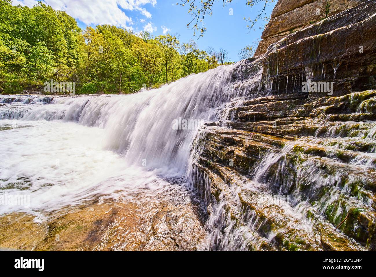Up close of waterfall with cascading falls over mossy rock Stock Photo ...