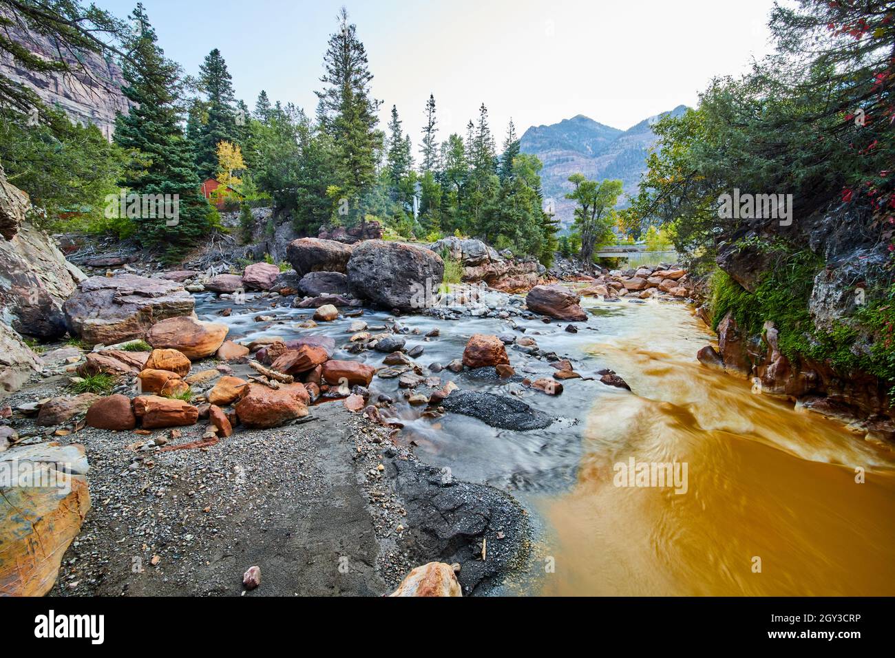 Close view of red rocks at river intersection with mountains in ...