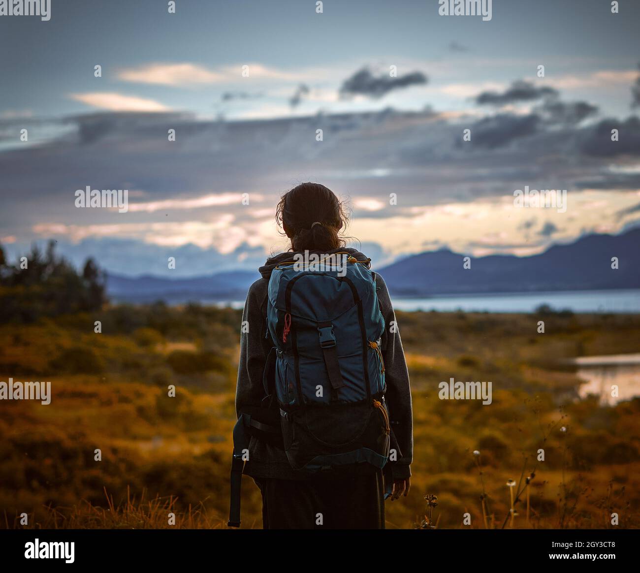 Man watching the sunset on a lake Stock Photo - Alamy