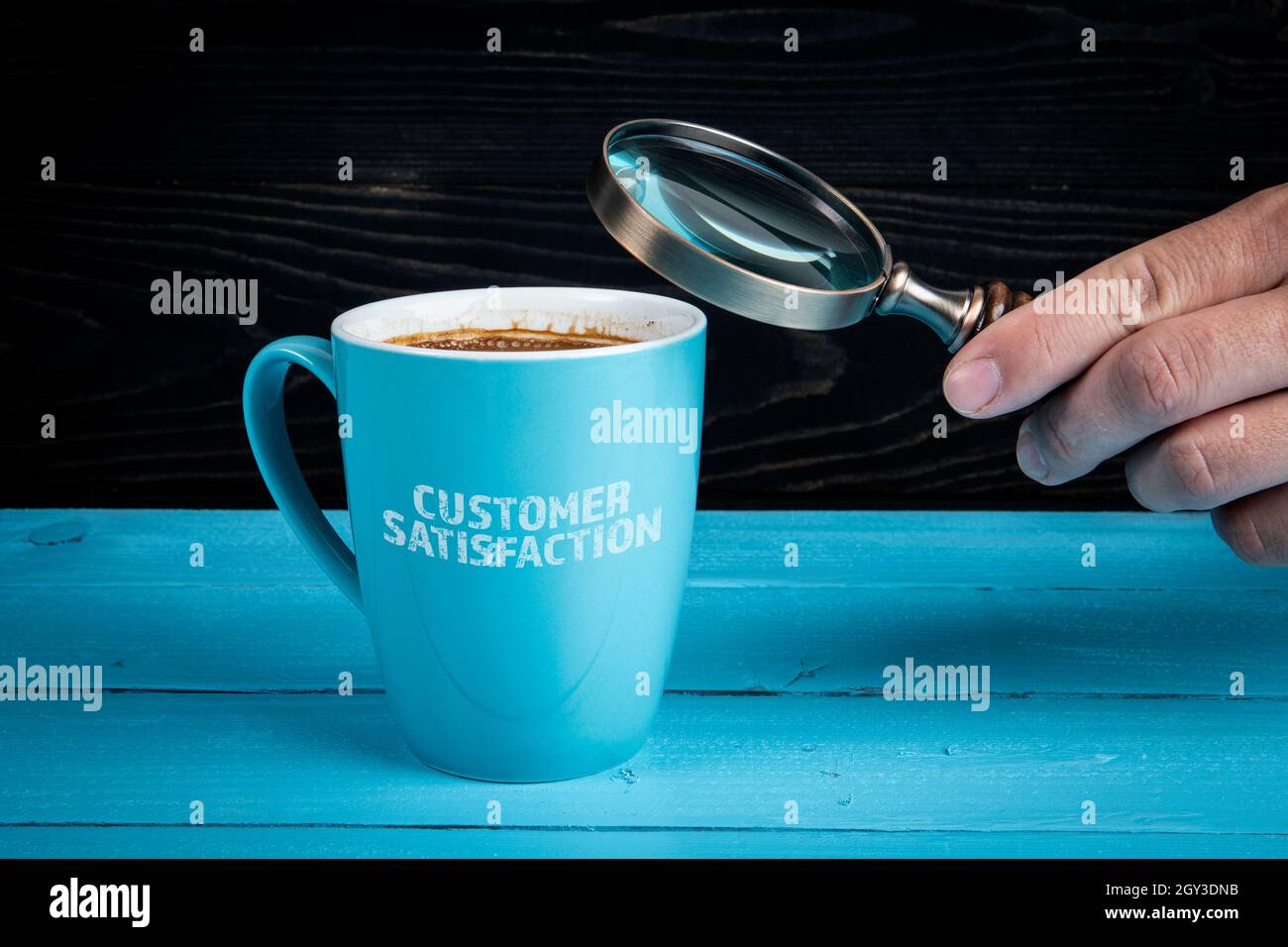 Customer Satisfaction concept. Text on a coffee mug and a magnifying ...