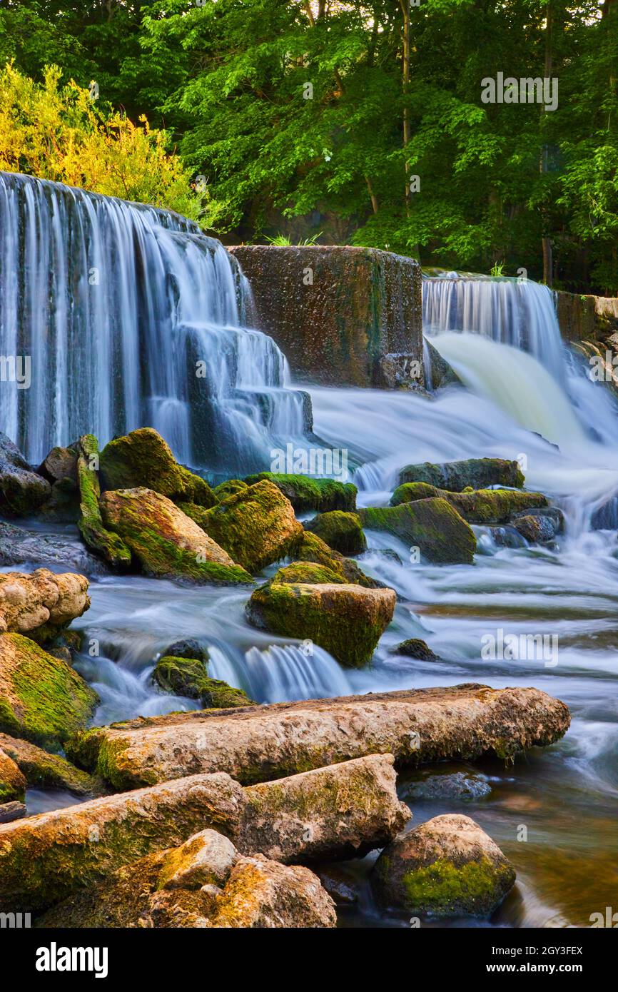 Beautiful small dam with cascading waterfalls over mossy rocks Stock ...