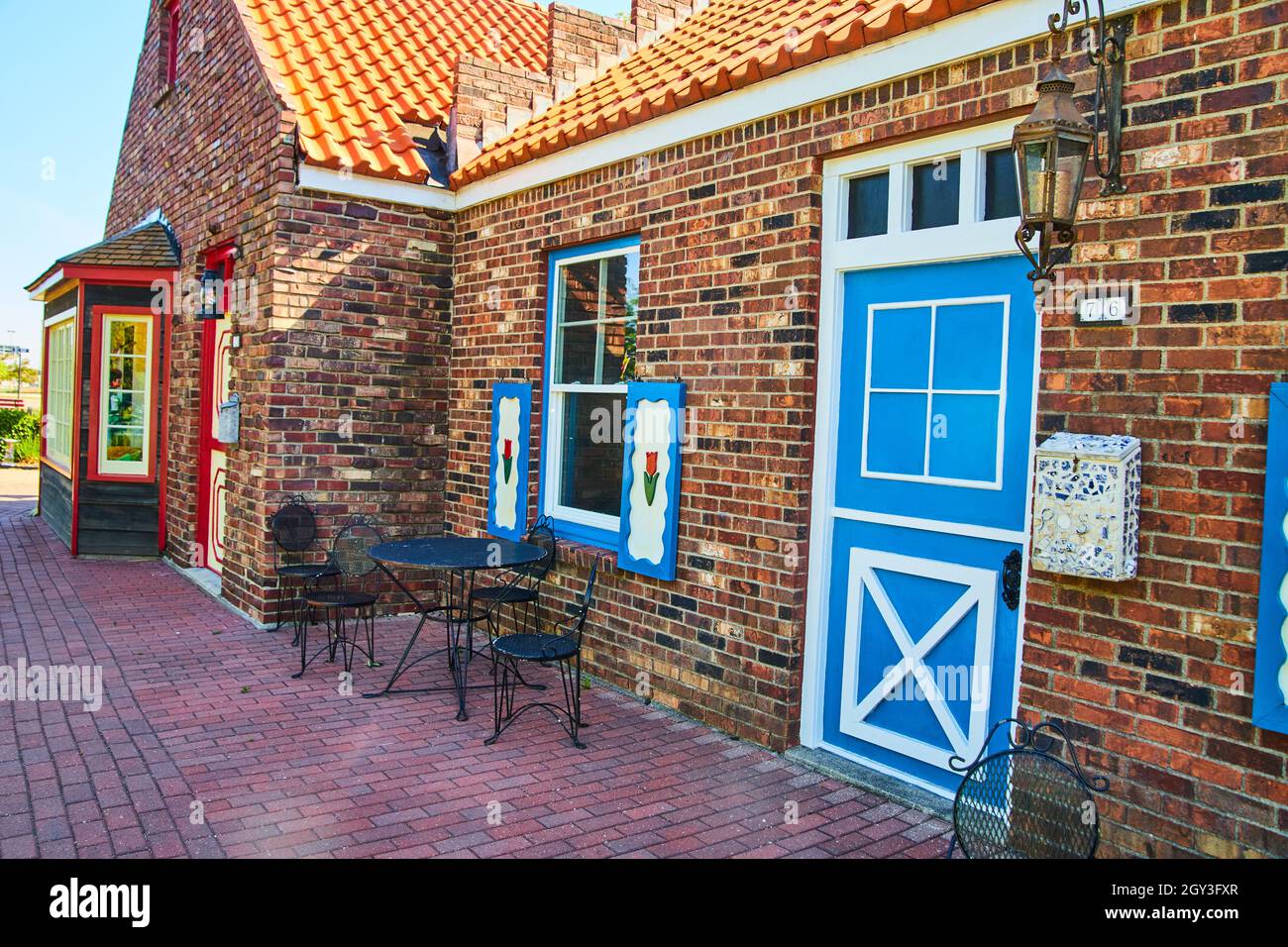 Shopping village storefronts of brick with colorful blue door Stock ...