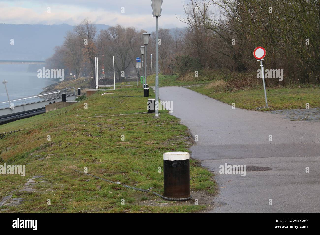 A walking path along a river with a pier on the side Stock Photo - Alamy
