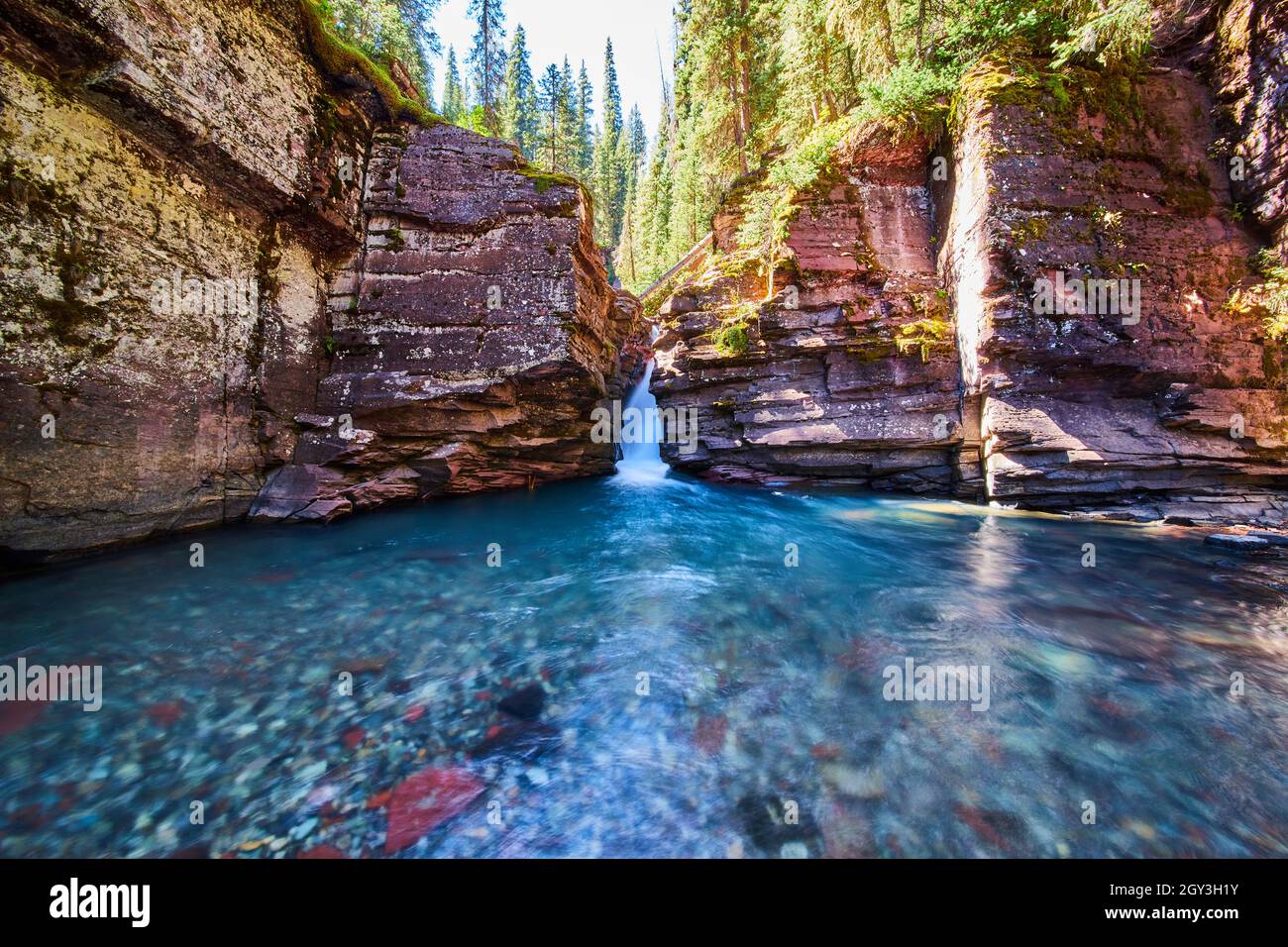 Amazing colorful blue river at bottom of gorge with cliffs covered in ...
