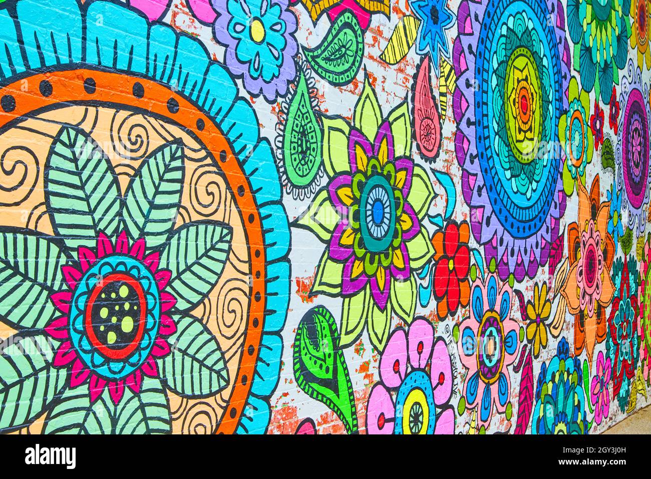 Brock wall covered in graffiti art of colorful flowers Stock Photo - Alamy