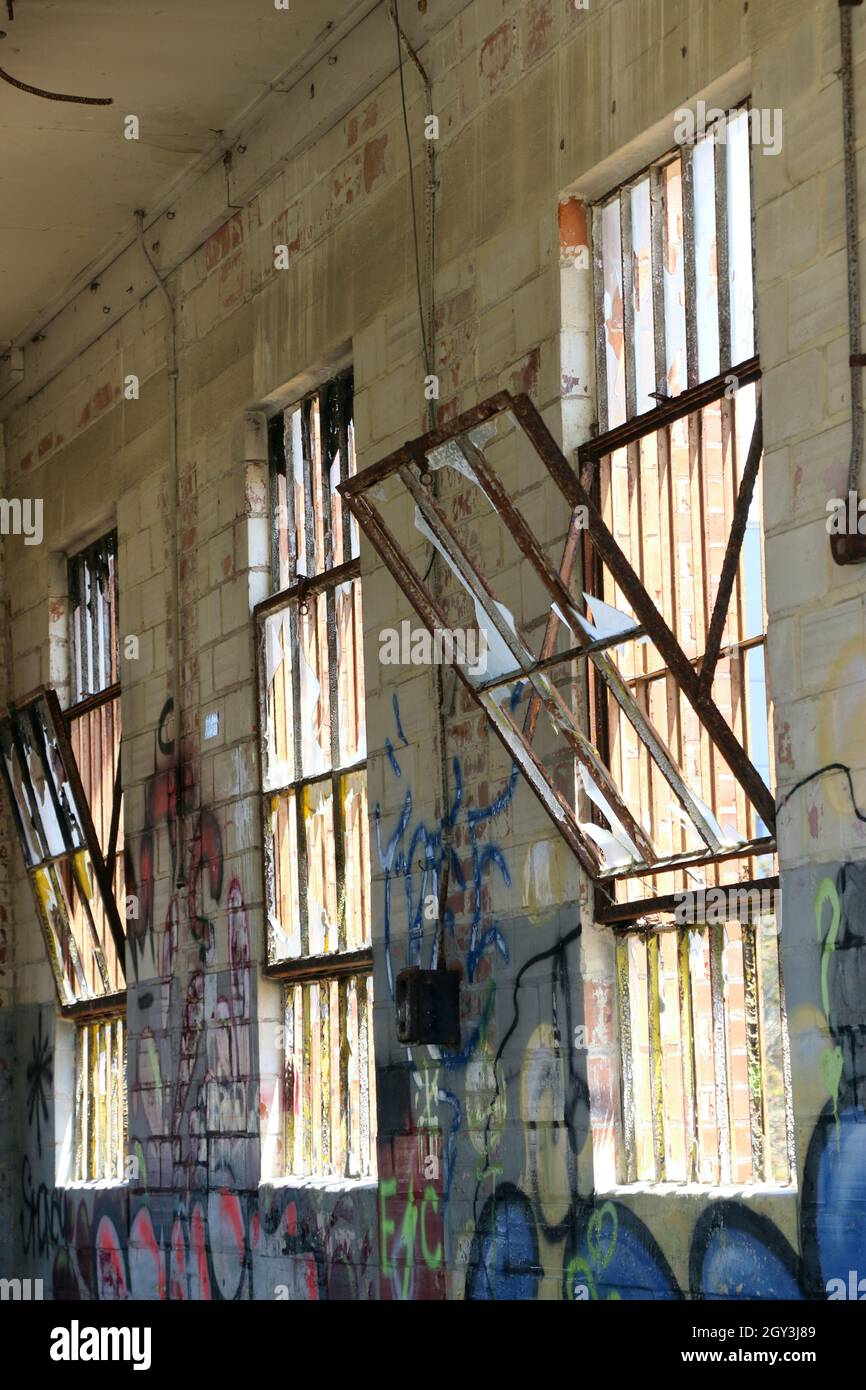 Rusted vintage hopper windows tilt inwards in an old, abandoned ...