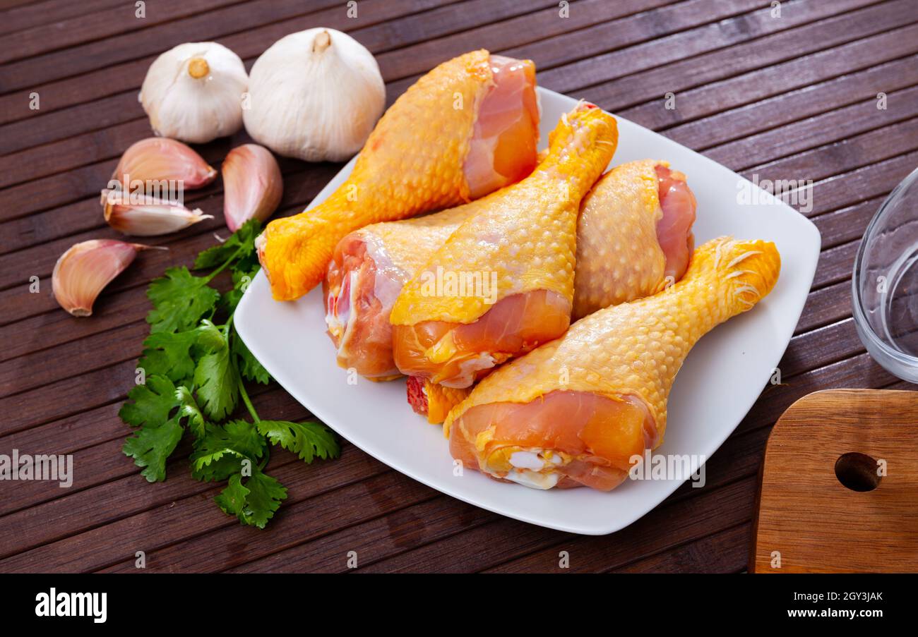 Raw chicken hams before cooking with greens and garlic Stock Photo - Alamy
