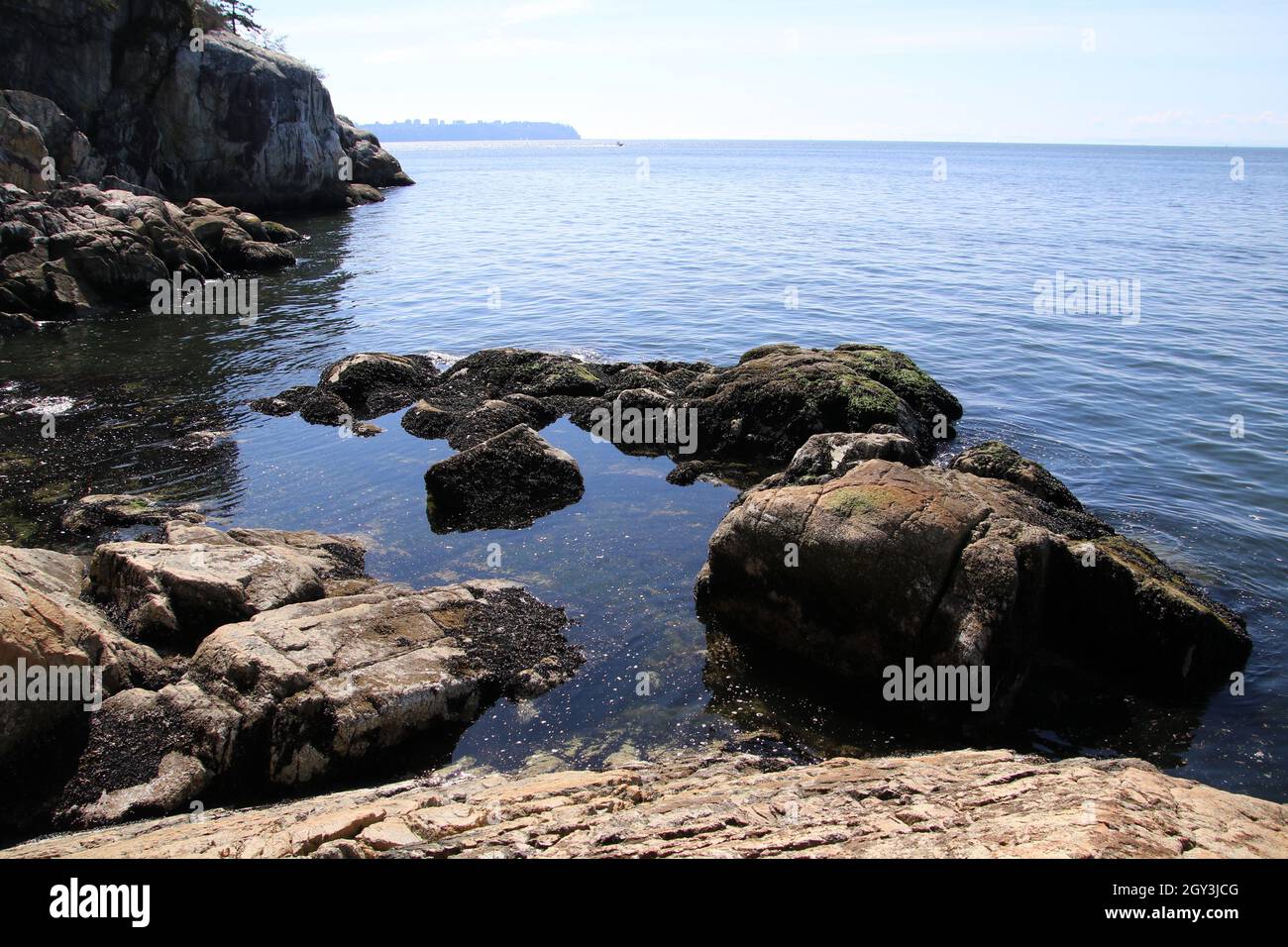 A view of the edge of a rocky coastline with a short rock cliff on the ...