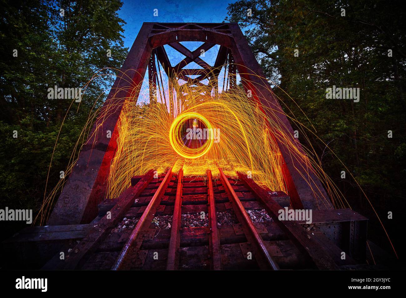 Train track bridge with spiral of orange sparks Stock Photo - Alamy