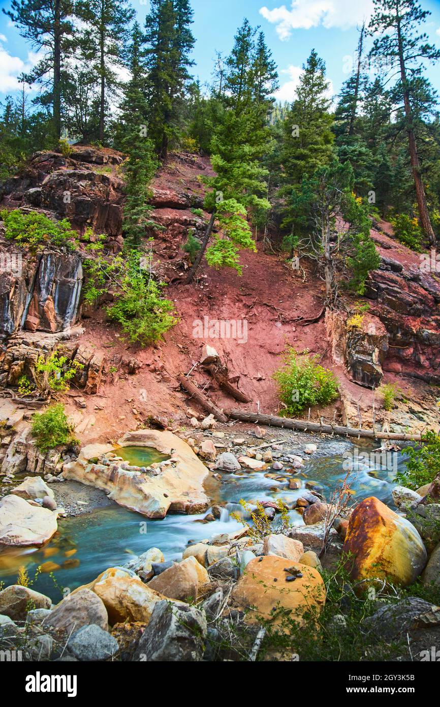 View of river with secret hot spring against red desert hills Stock ...