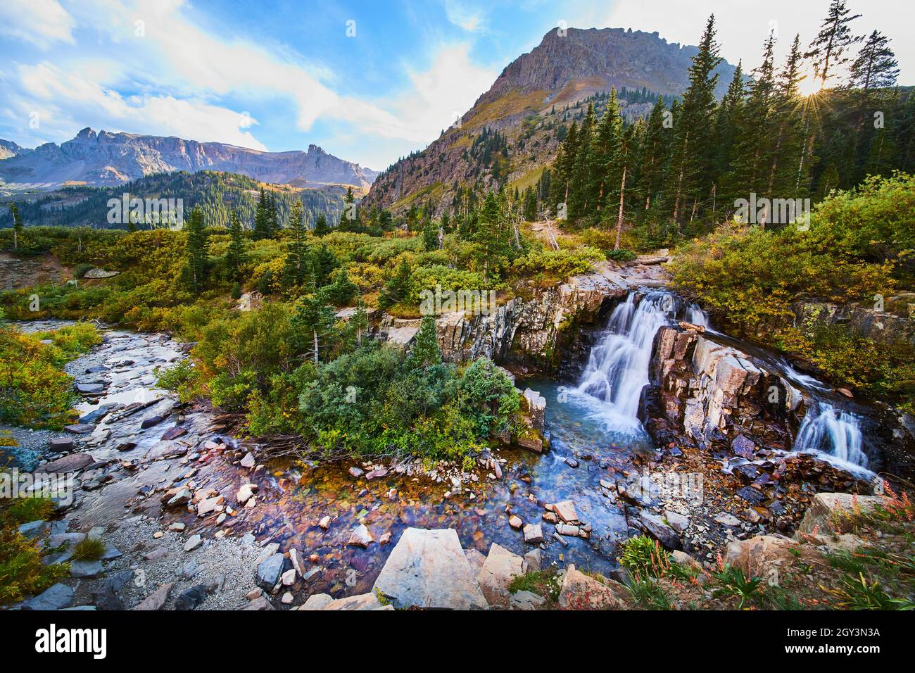River with large beautiful waterfall winding through mountain valley ...
