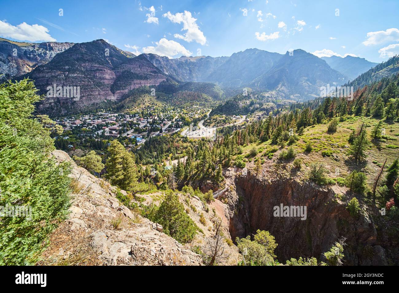 Small town surrounded by mountains from overlook above walking bridge ...
